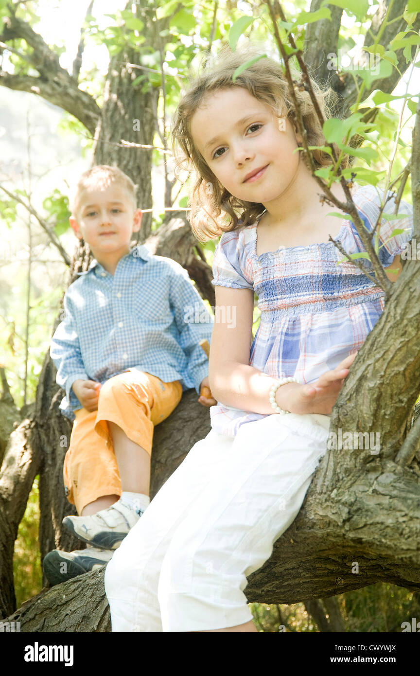 Boy and girl sitting in tree Stock Photo - Alamy