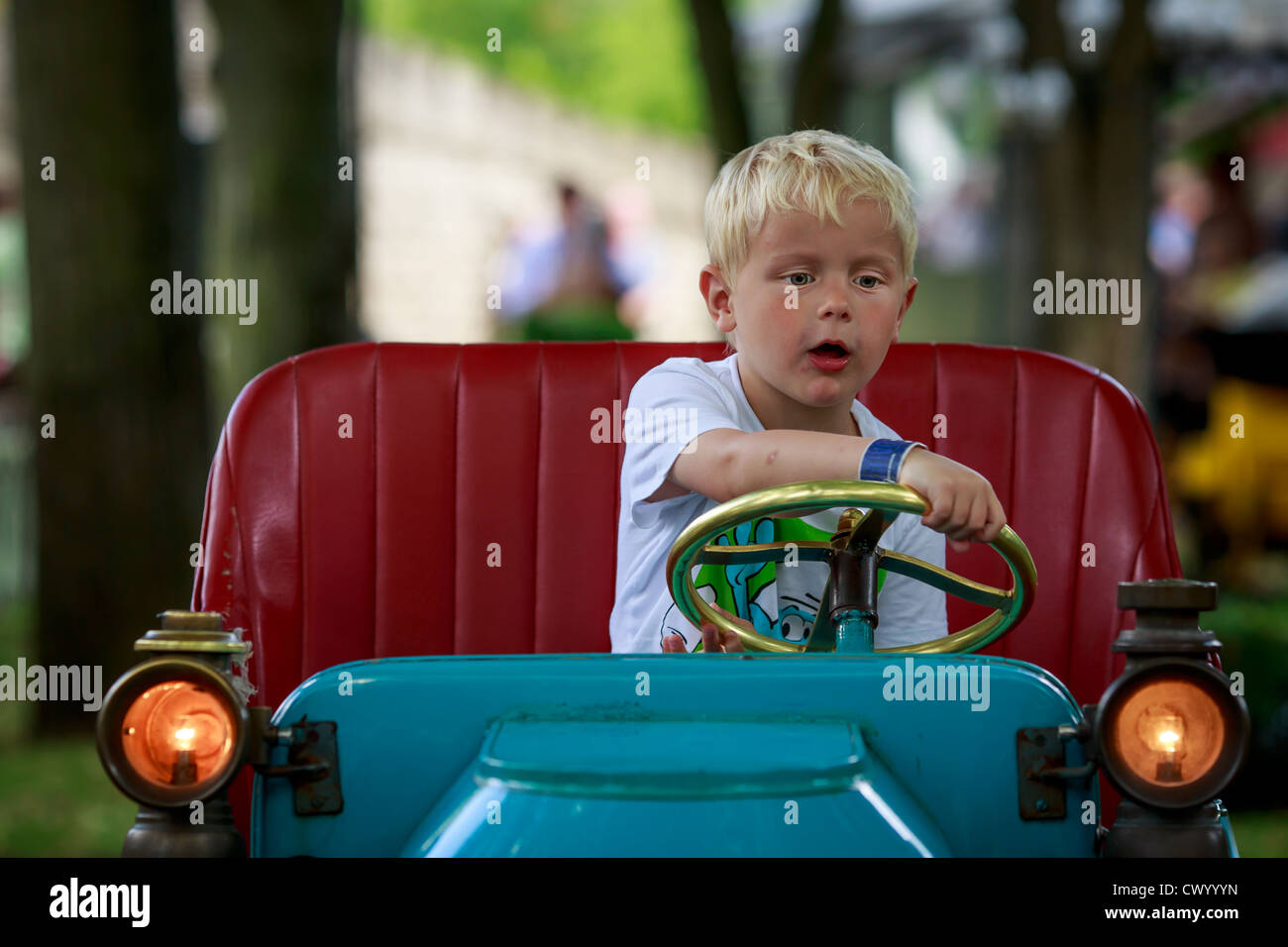 A boy drive a model vintage car in Tiovli, Copenhagen, Denmark Stock ...