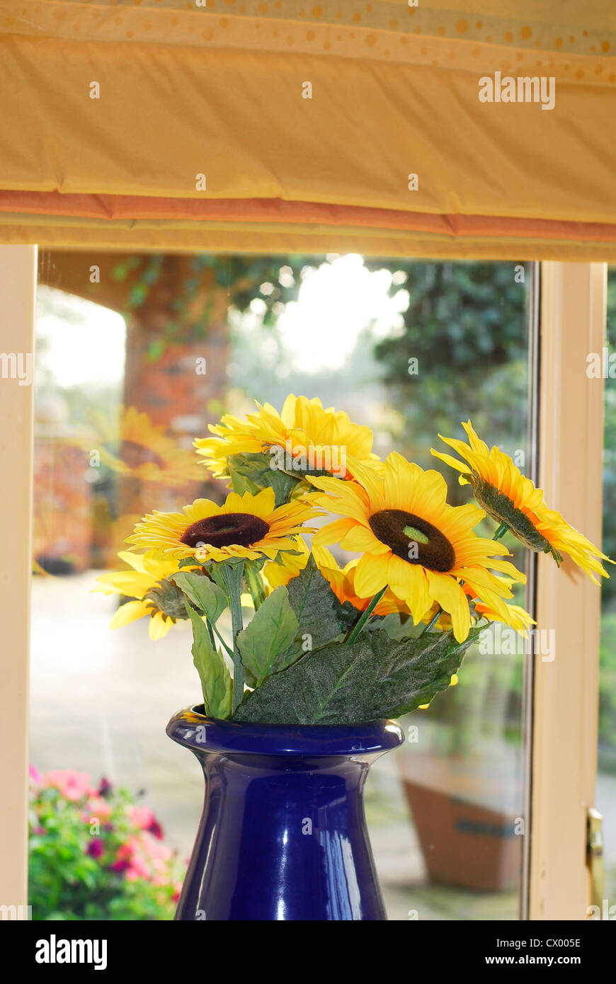 Artificial sunflowers in window Stock Photo - Alamy