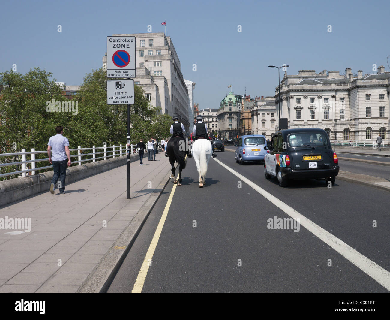 Two women police horse riders on patrol crossing Waterloo Bridge ...