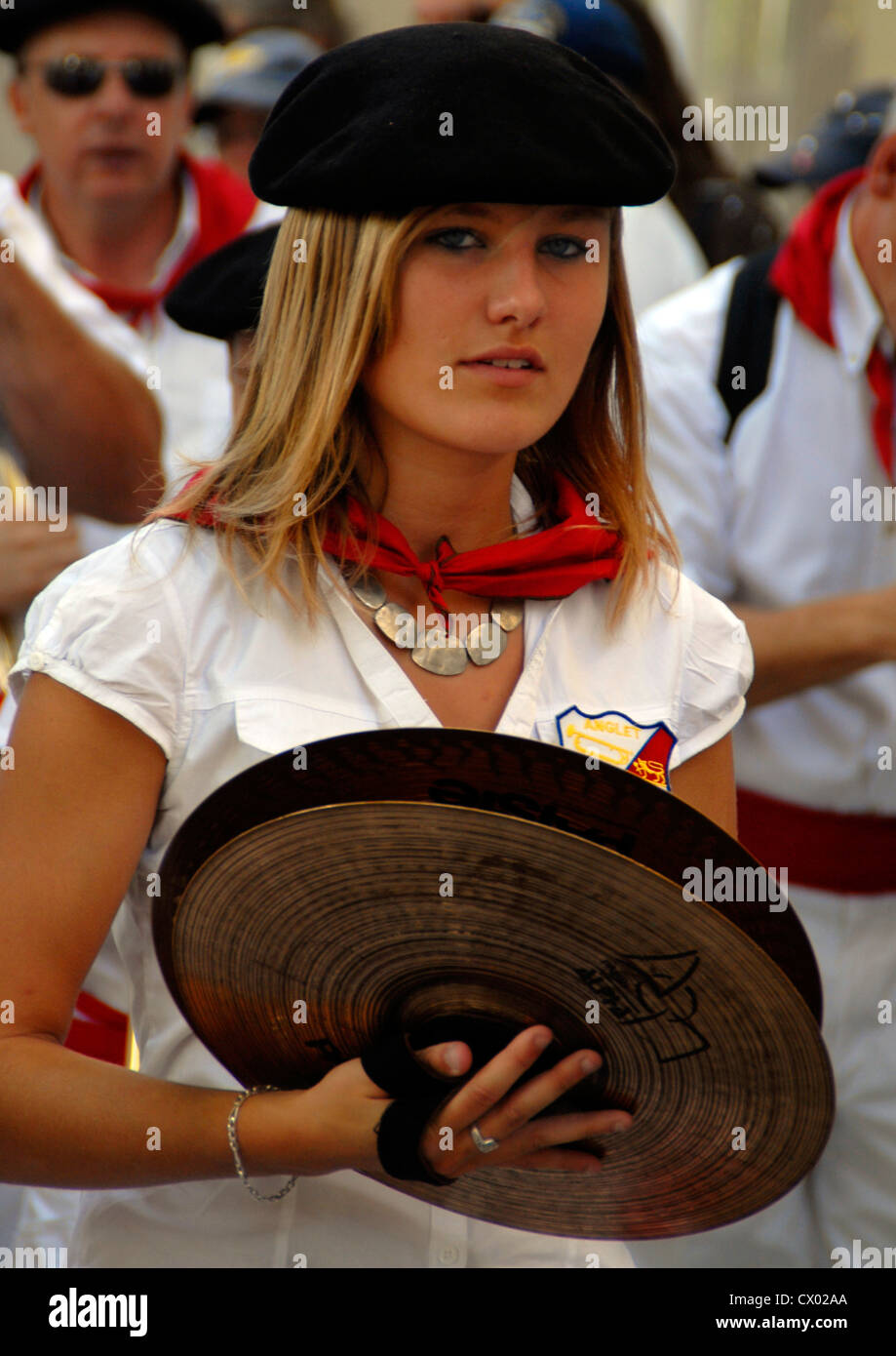 French girl in beret plays the cymbals in a band on fete day at Salies ...