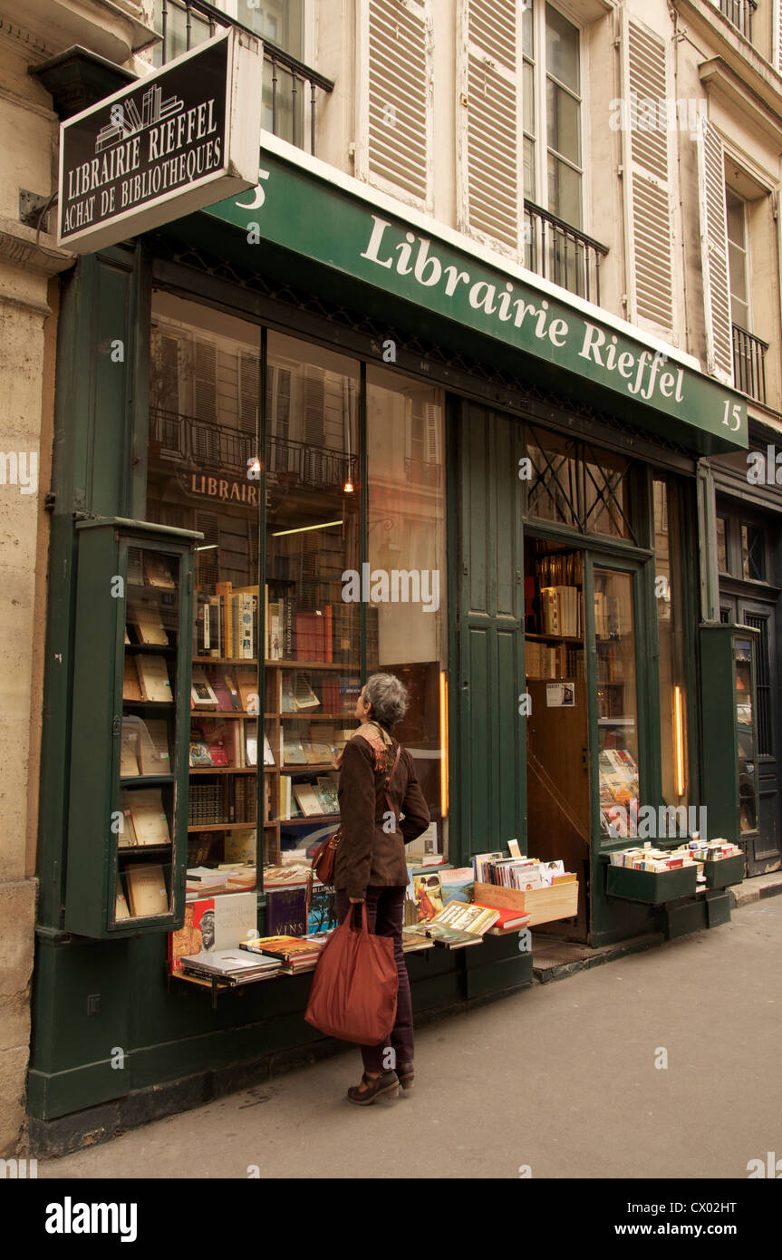 A window-shopper stands on tip-toe to get a better view of the books in ...