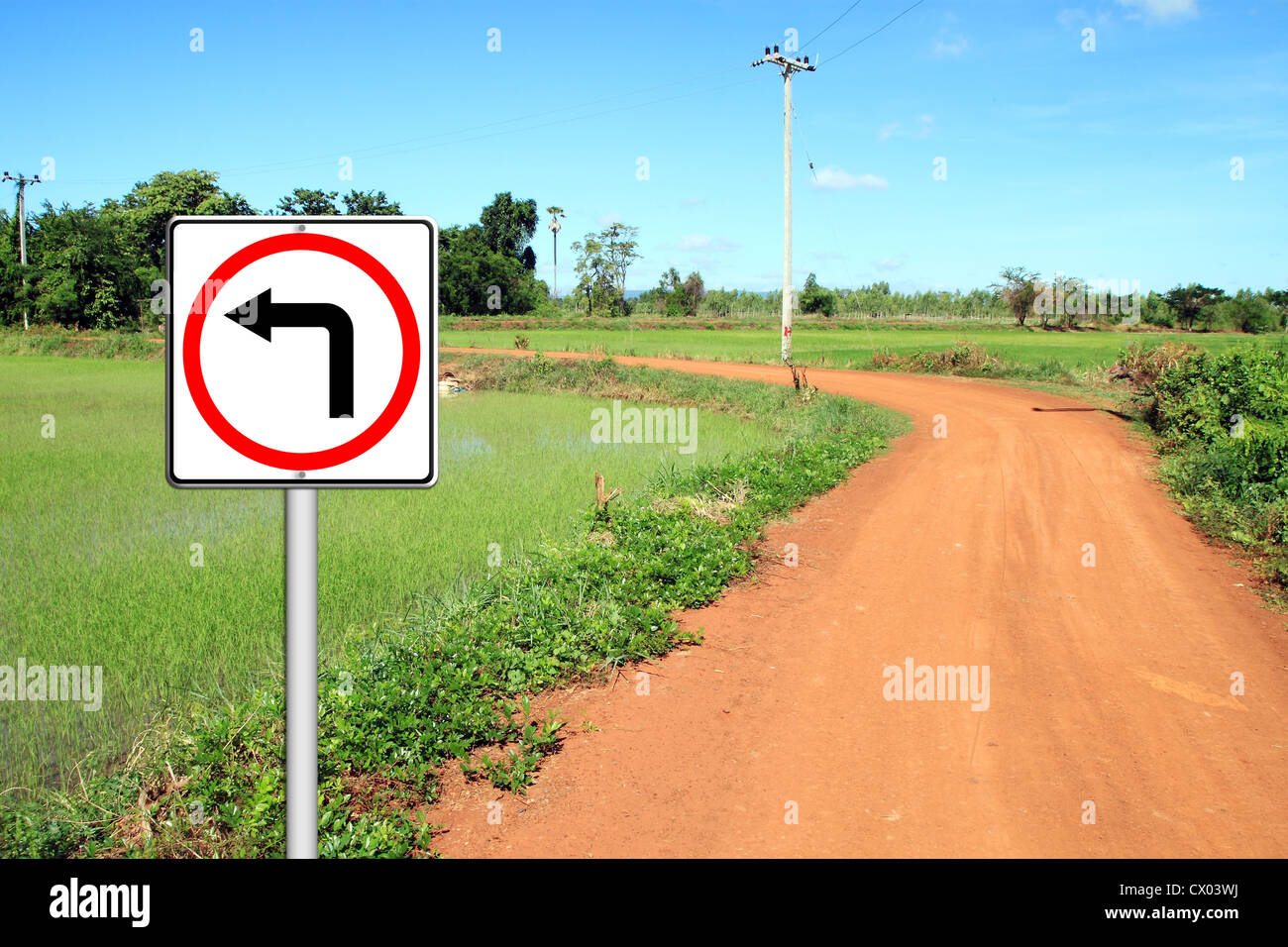 Turn left sign with soil road in countryside Stock Photo - Alamy