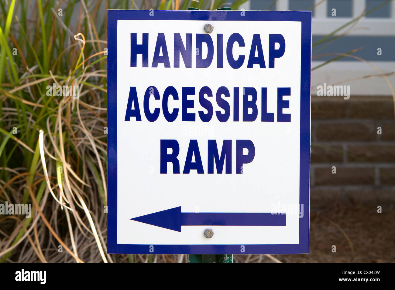Sign in front of a building points to a handicapped accessible ramp for ...
