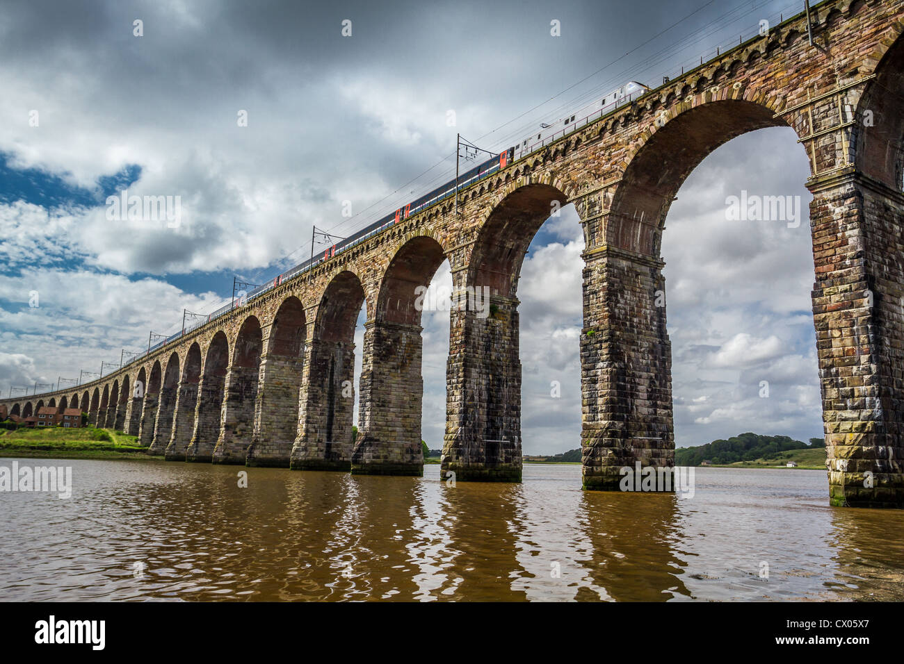 View of the train passing through the old stone bridge in Scotland ...