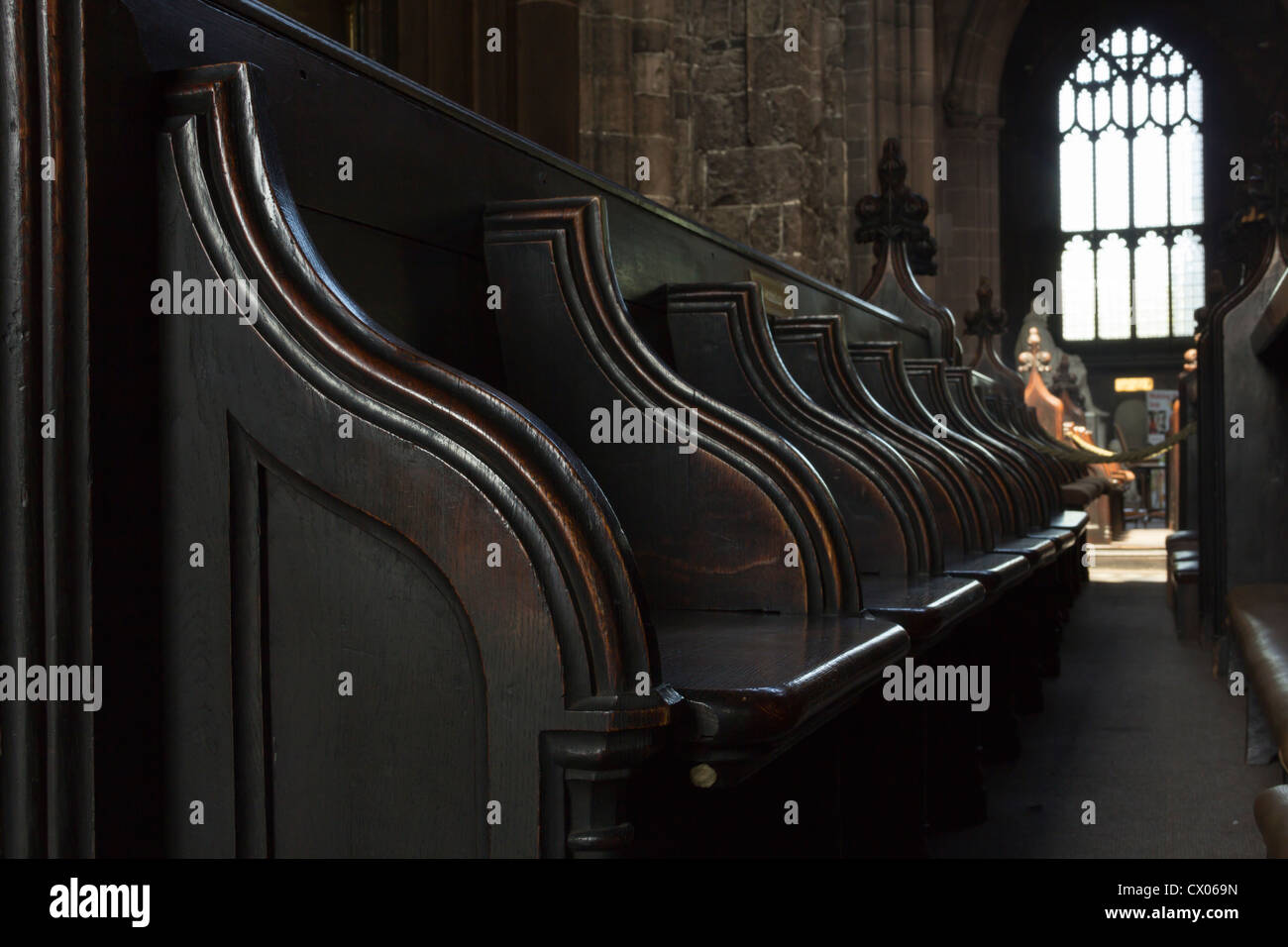 Old carved wood pew type seating at the rear of the nave of Manchester ...