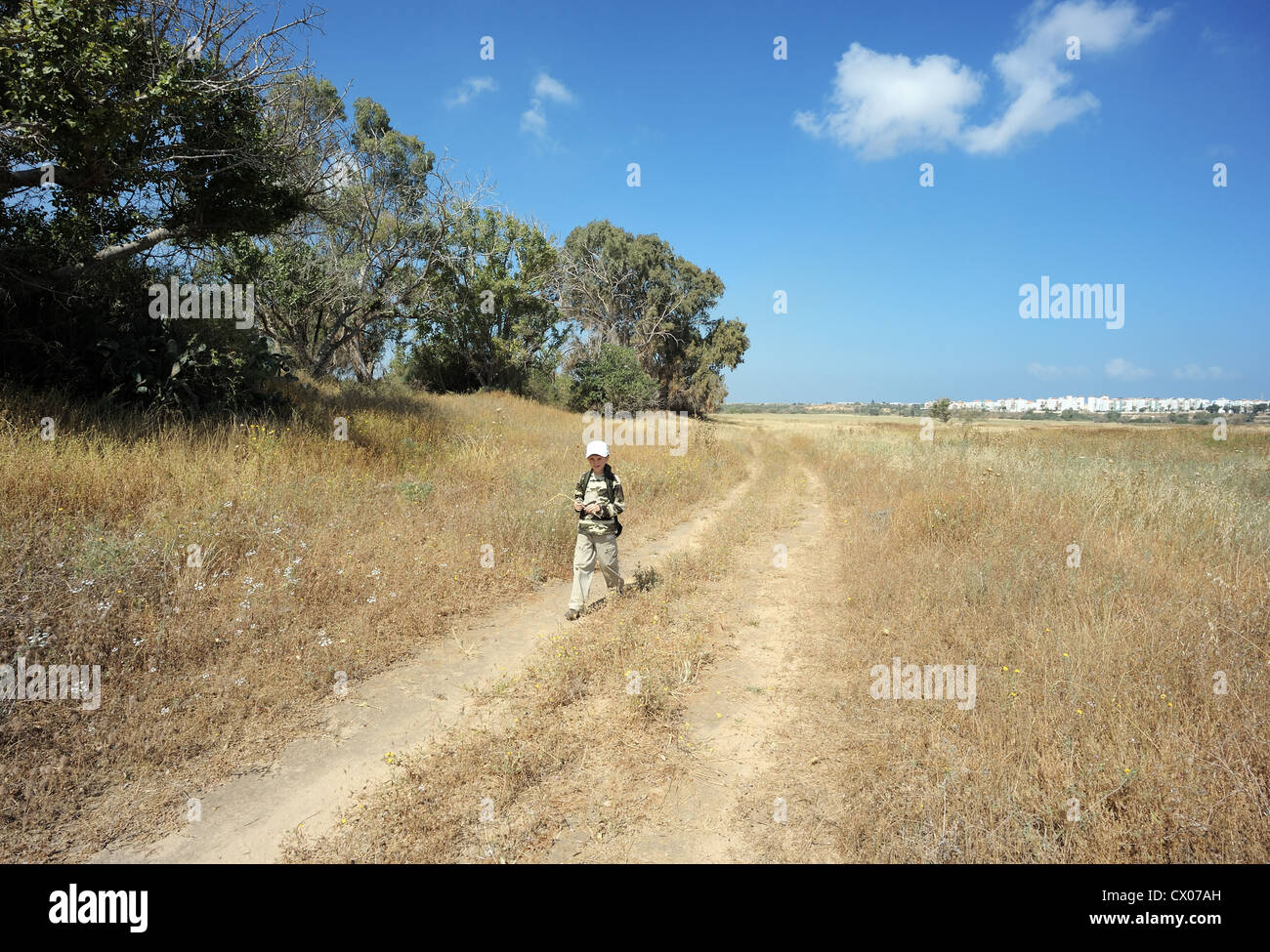 The boy, going on the road along the edge of the field Stock Photo - Alamy