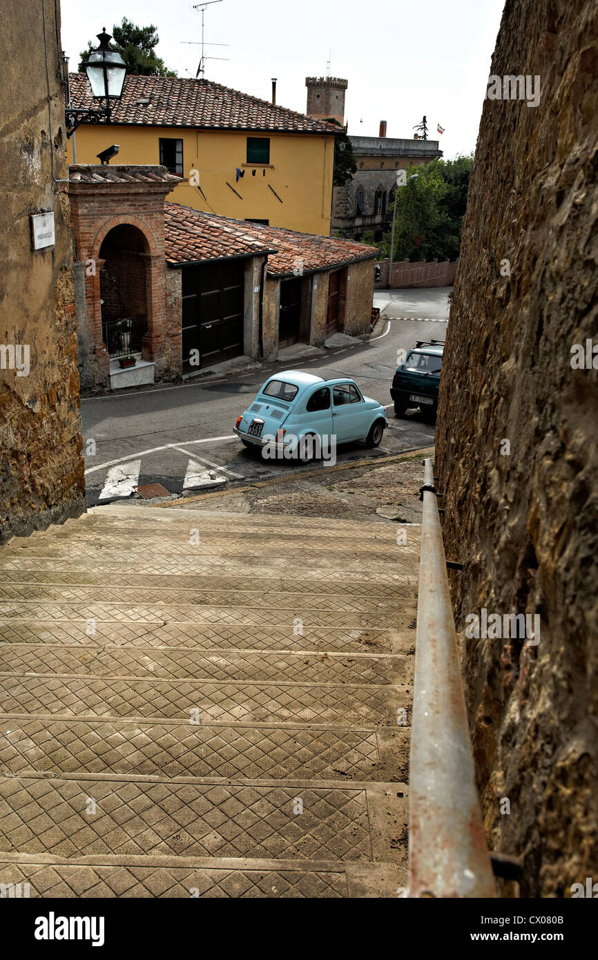 Looking down stairway to old light blue Fiat 500 parked in street ...