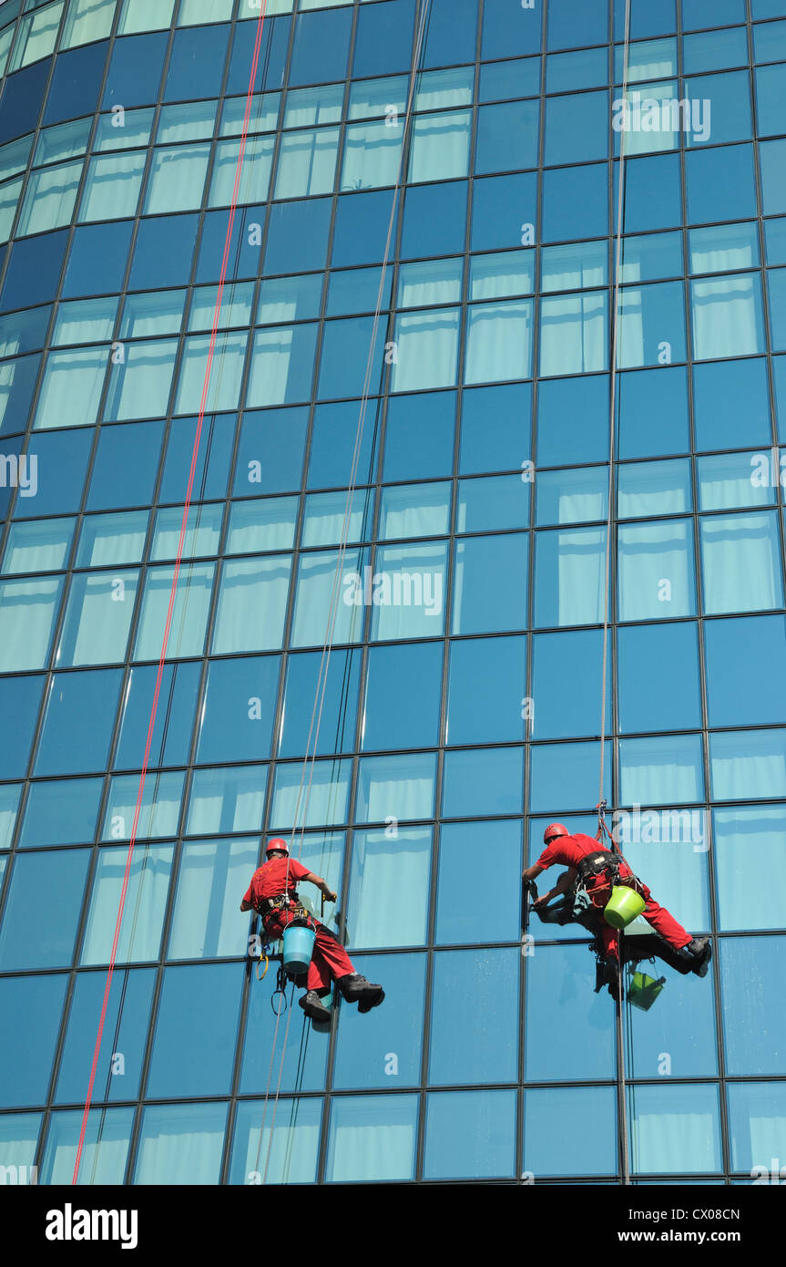 Two windows washer cleaning the high building glass Stock Photo - Alamy