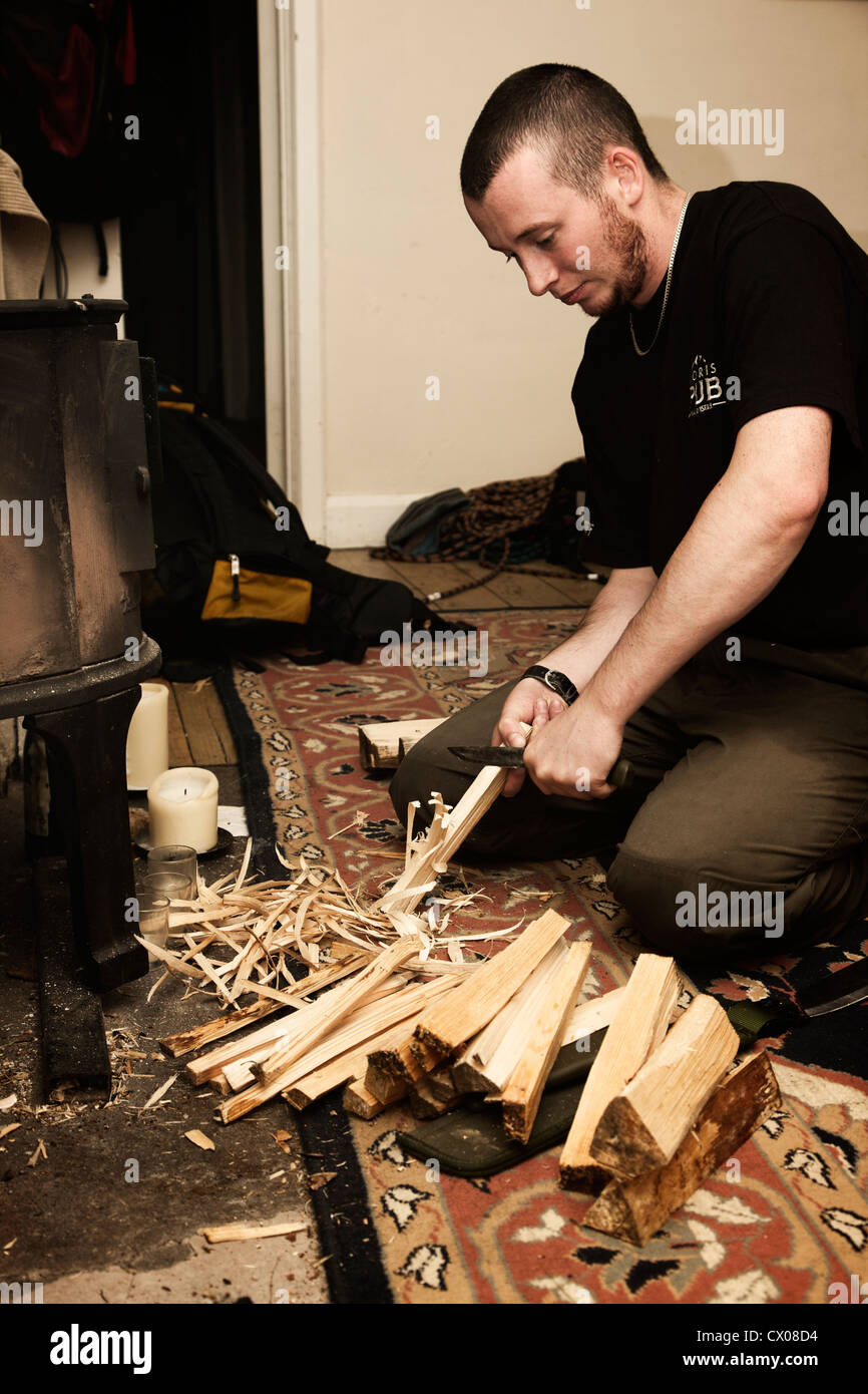 Man making tinder for wood burning fire stove Stock Photo - Alamy