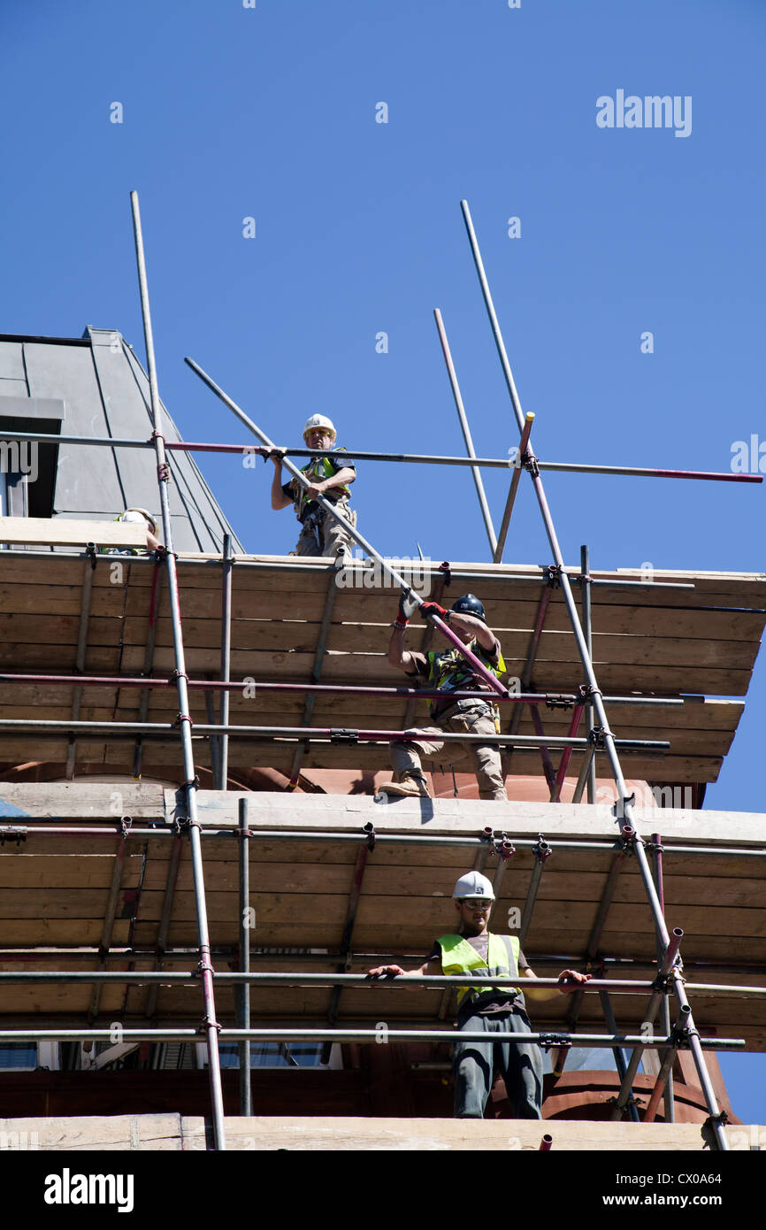 Construction Workers passing poles of Scaffold upwards - London UK ...
