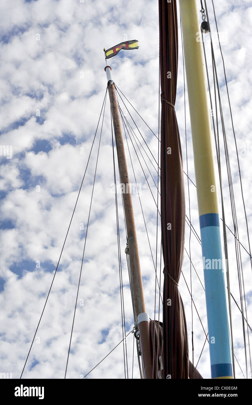 seen from below ships rigging mast and flag against sky and clouds ...