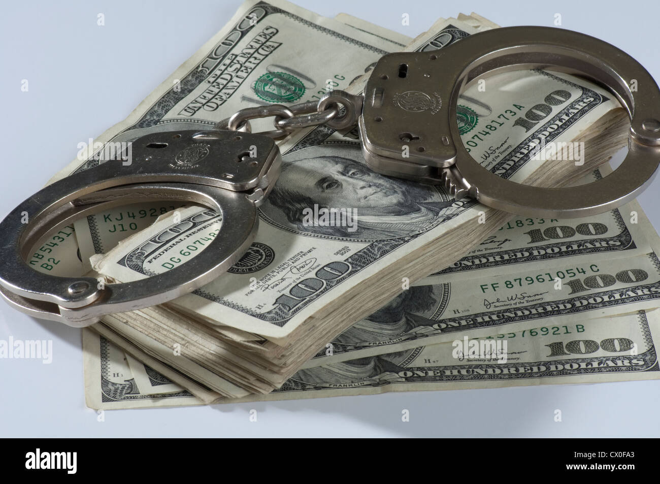 stack of $100 bills and handcuffs Stock Photo - Alamy