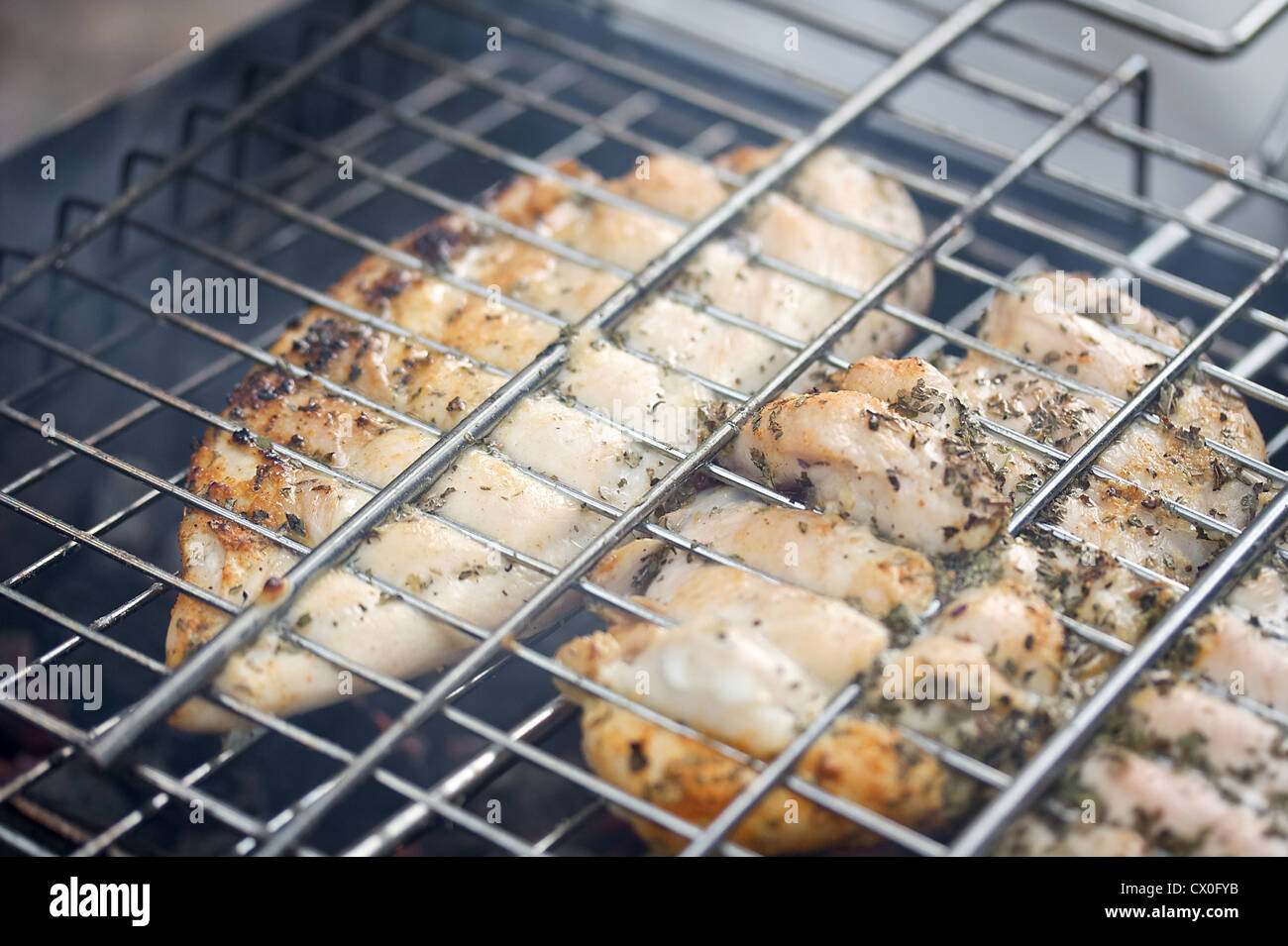 Barbecue with chicken in metal grate, closeup Stock Photo - Alamy