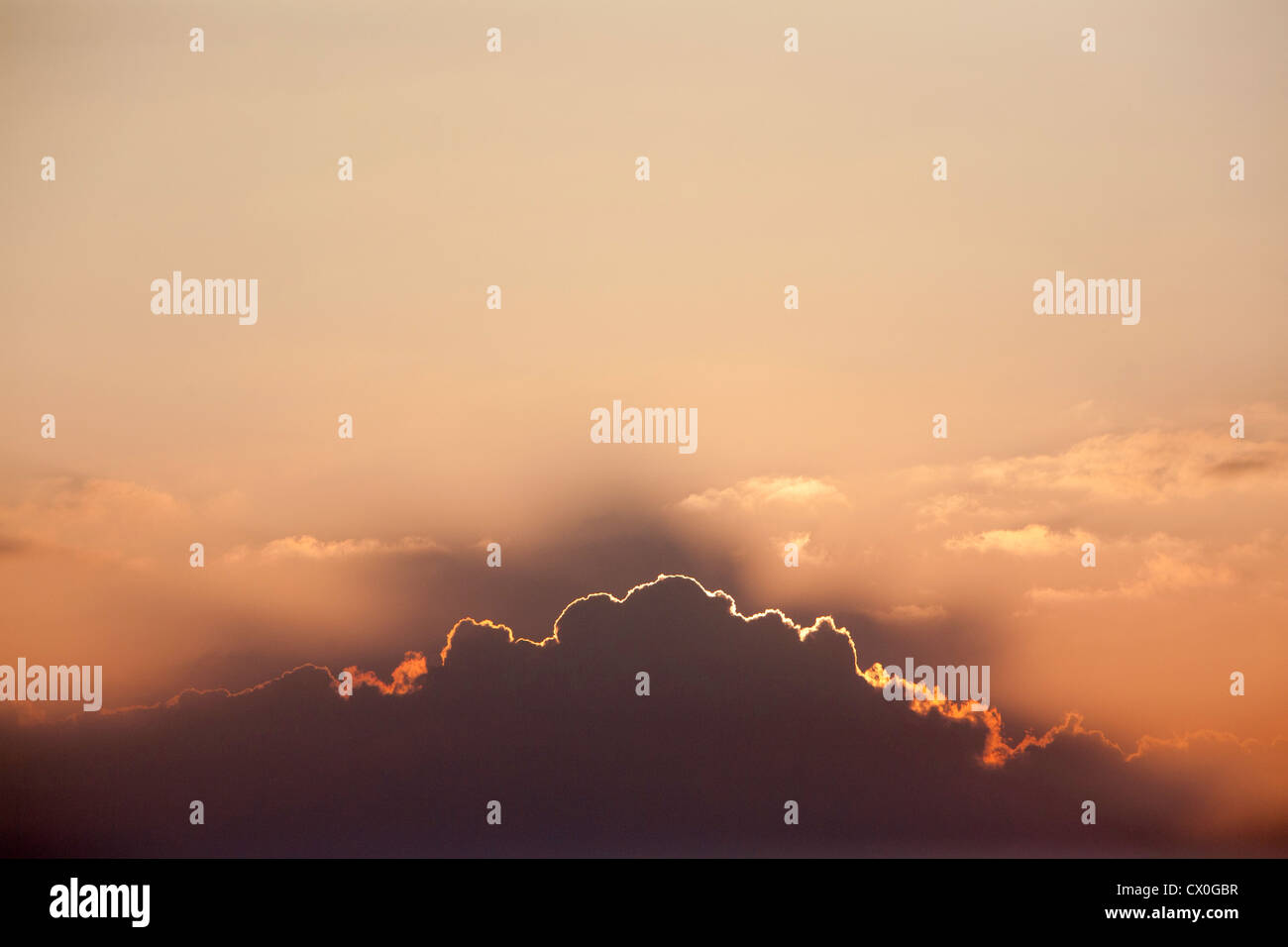 Silver lining as the sun disappears behind a line of clouds Stock Photo ...