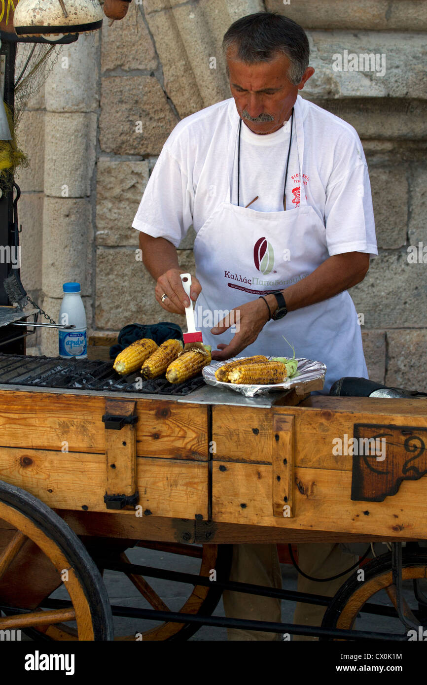 A street trader selling hot fast food corn on the cobs in Rhodes Town ...