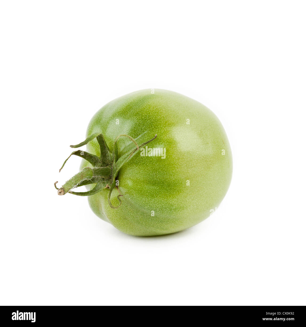Green tomato closeup on white Stock Photo - Alamy