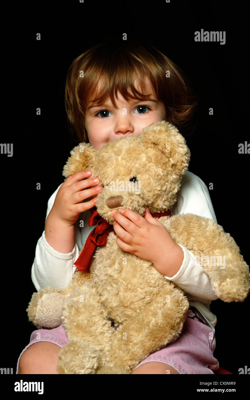 Little girl cuddling a teddy bear Stock Photo - Alamy