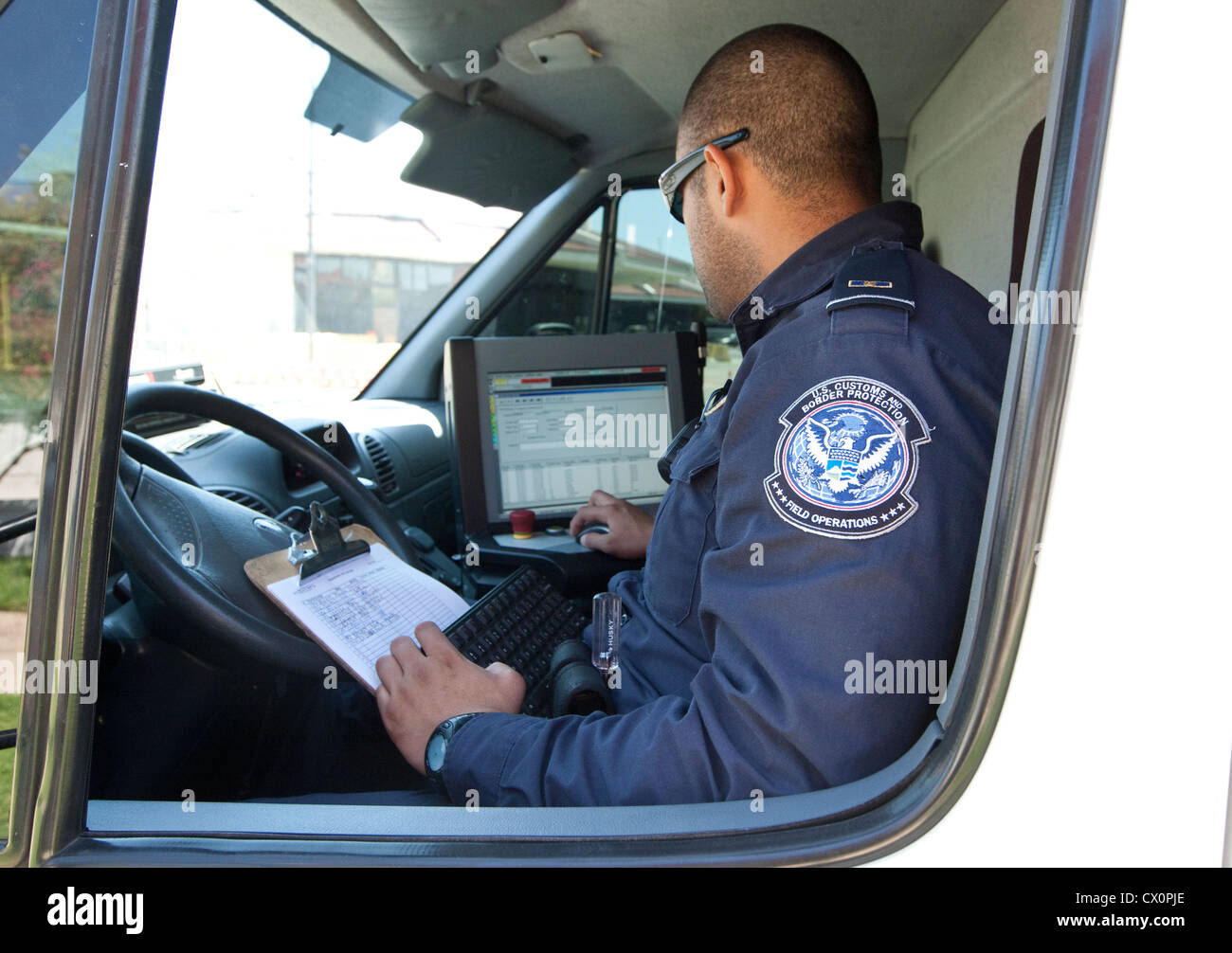 Officer drives a mobile X-ray van scans several vehicles headed to ...