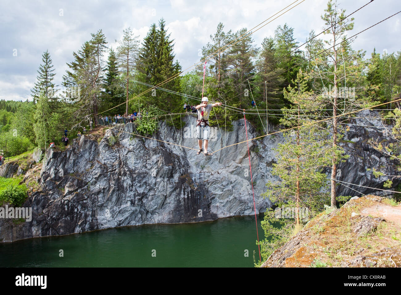 People transition the rope bridge over a flooded marble quarry in ...