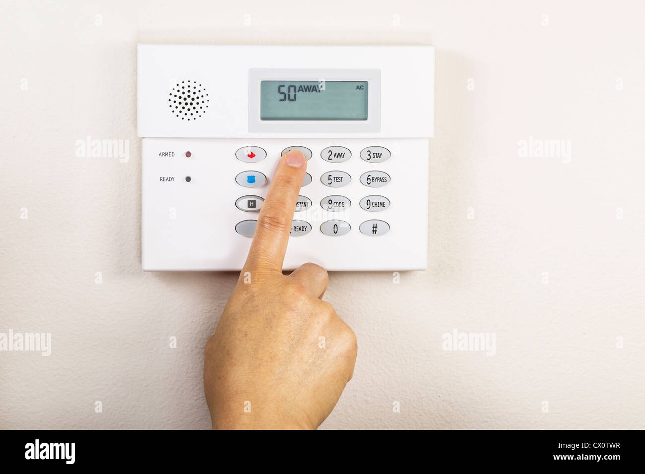 Hand setting the away code on home alarm security panel Stock Photo - Alamy