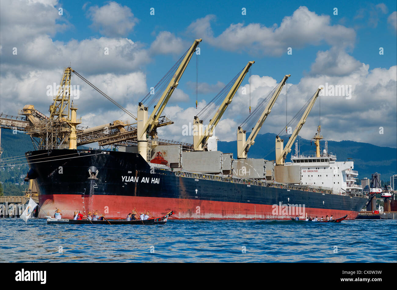 Salish First Nations canoes dwarfed by large ship, port of Vancouver ...