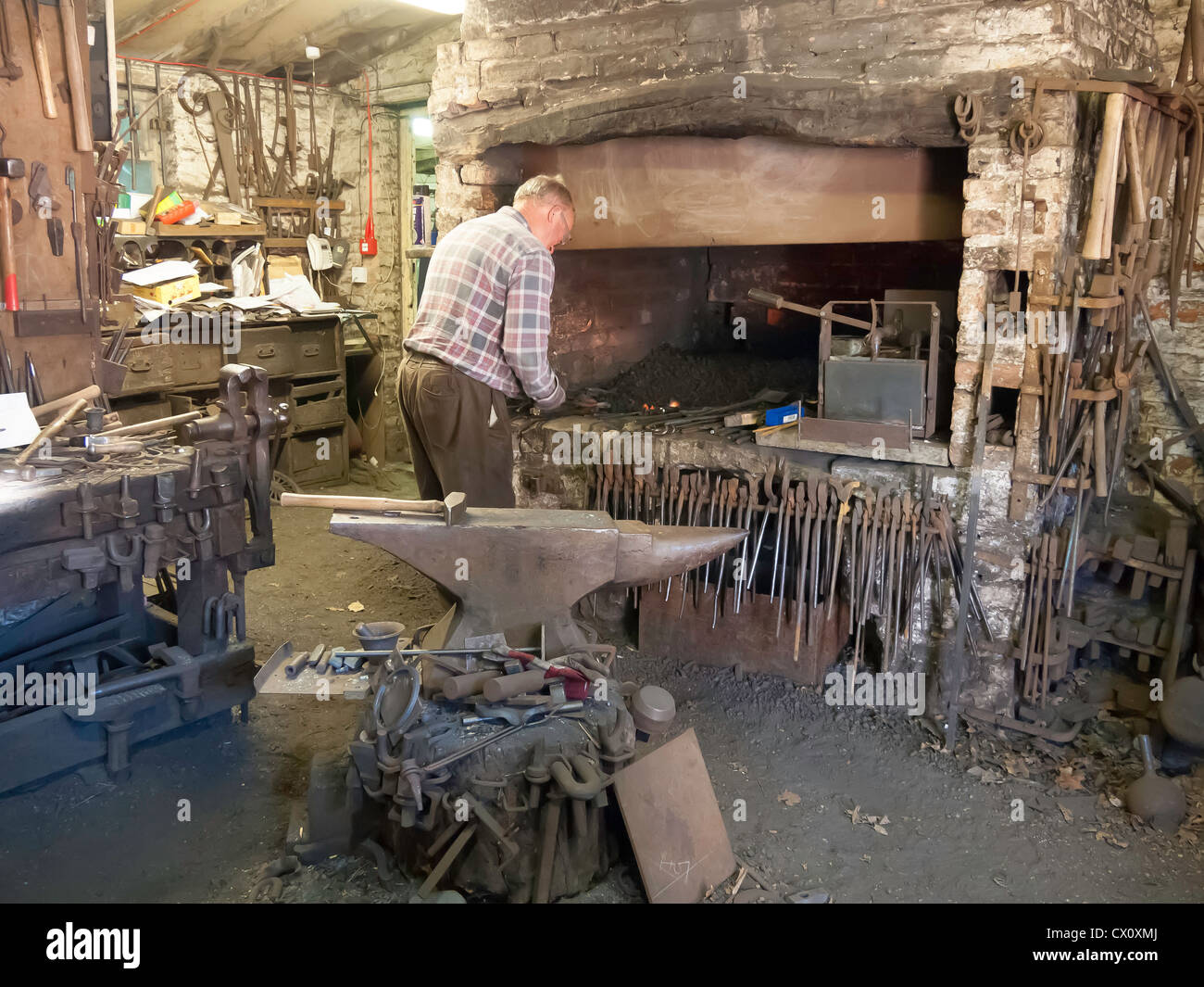 A blacksmith at work in a working forge in Preston Park Museum Stockton ...