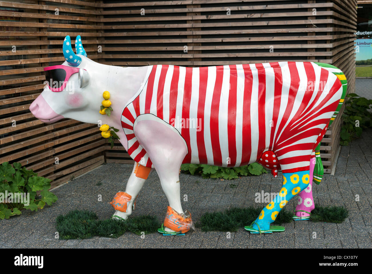 A model cow painted, decorated, dressed in colours and stripes wearing ...