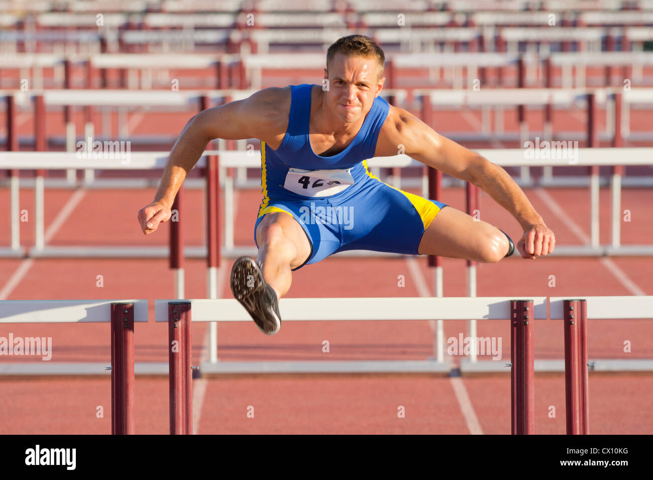 Male hurdler clearing hurdles Stock Photo - Alamy