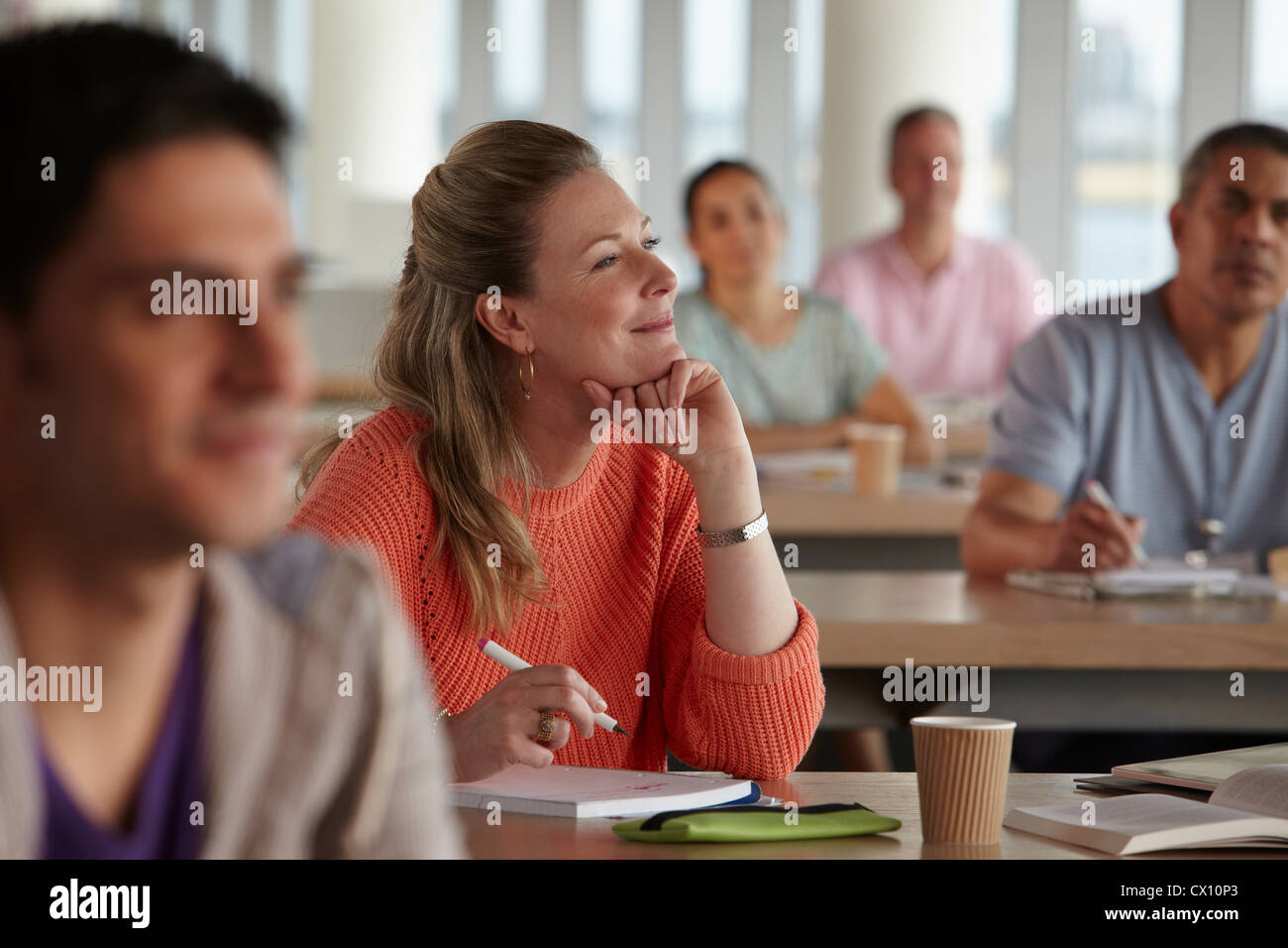 Mature students in class, woman with hand on chin Stock Photo - Alamy