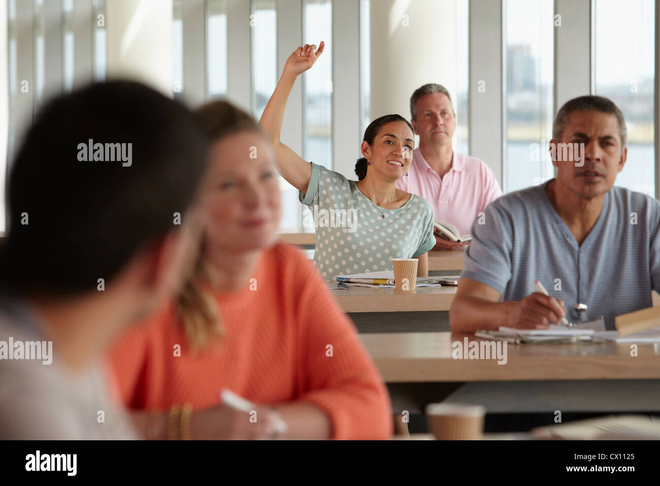 Mature students in class, woman with hand up Stock Photo - Alamy