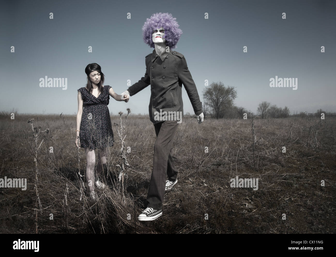 Bizarre couple in relationship conflict. Crazy clown and little girl ...