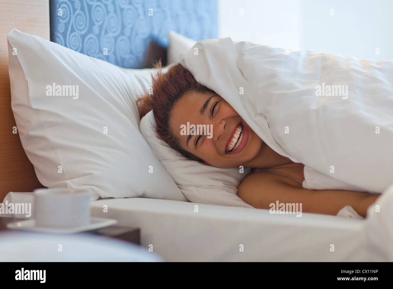 Happy young woman in bed Stock Photo - Alamy