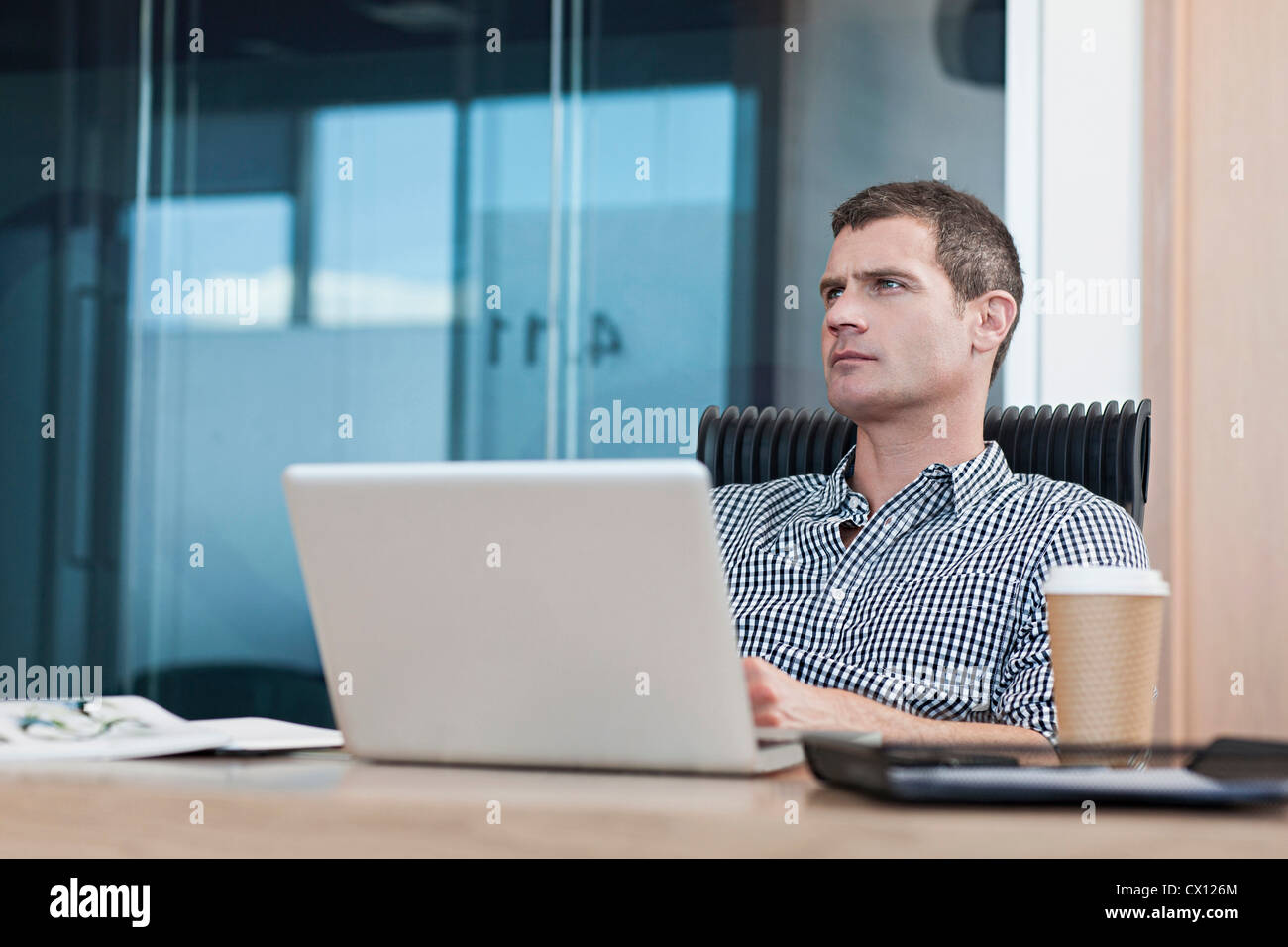 Man with laptop, looking away Stock Photo - Alamy