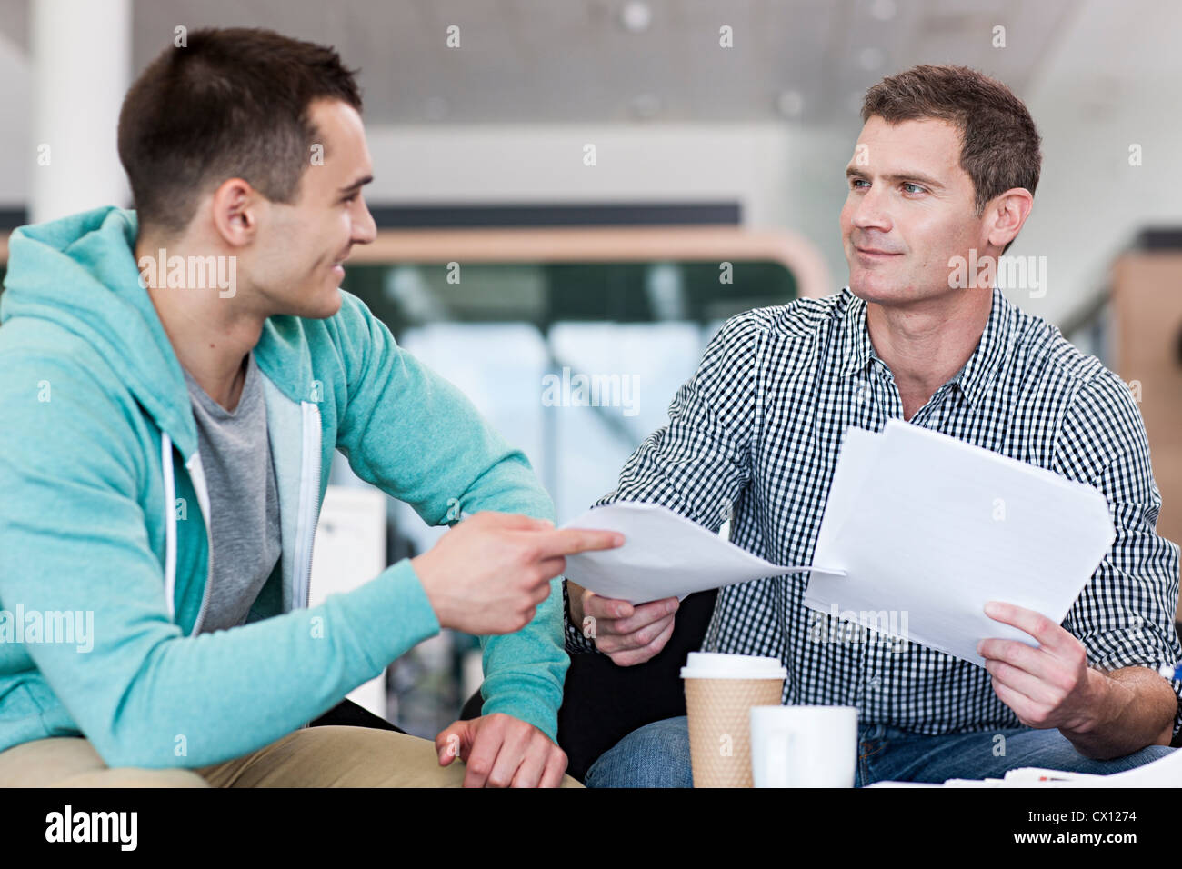 Man giving colleague document Stock Photo - Alamy