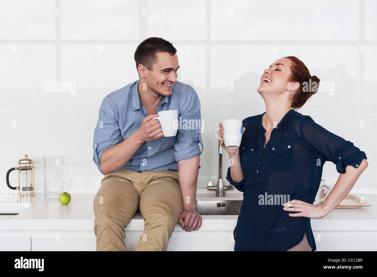 Colleagues laughing in kitchen Stock Photo - Alamy