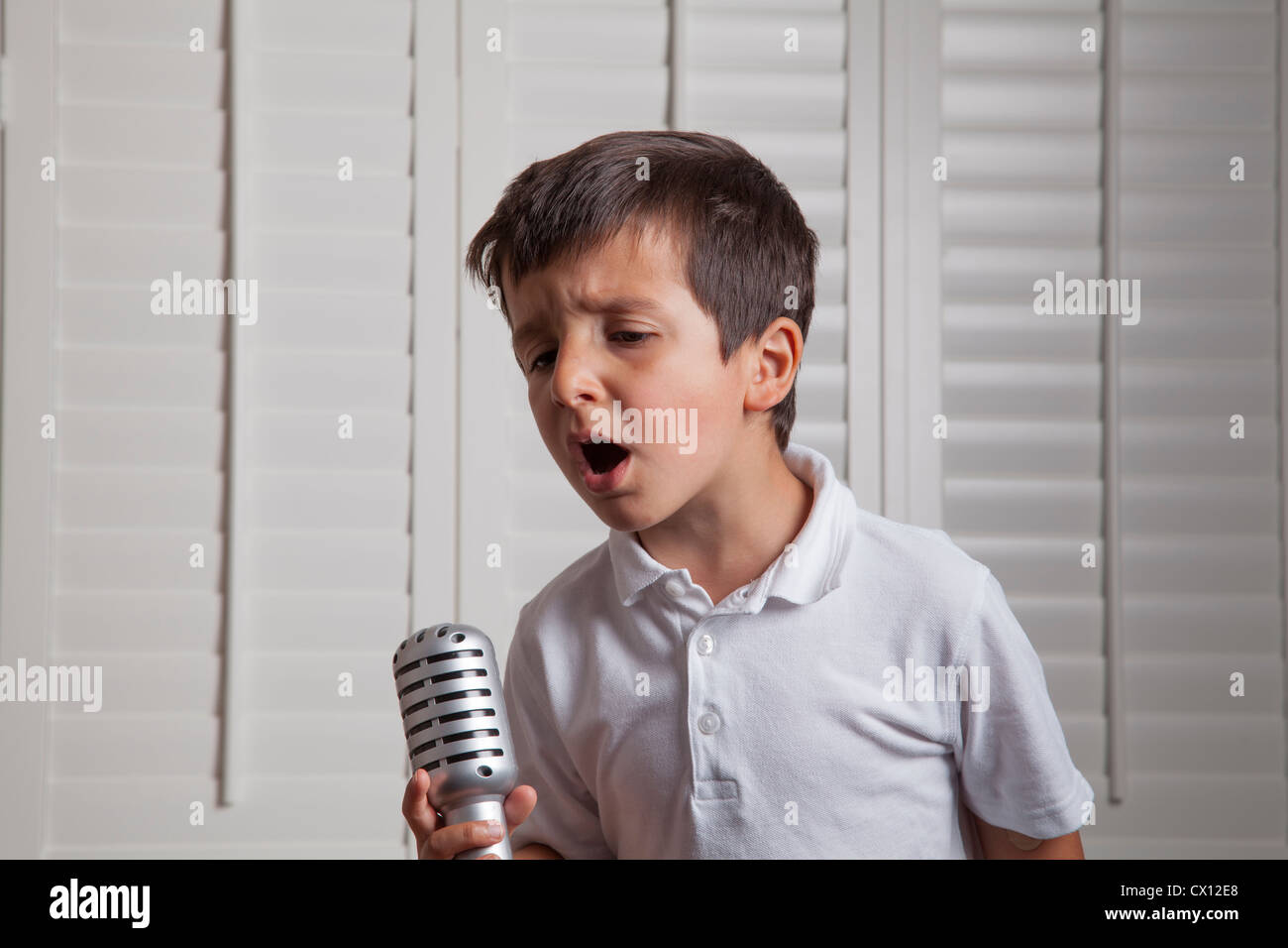 Boy sings in microphone Stock Photo - Alamy