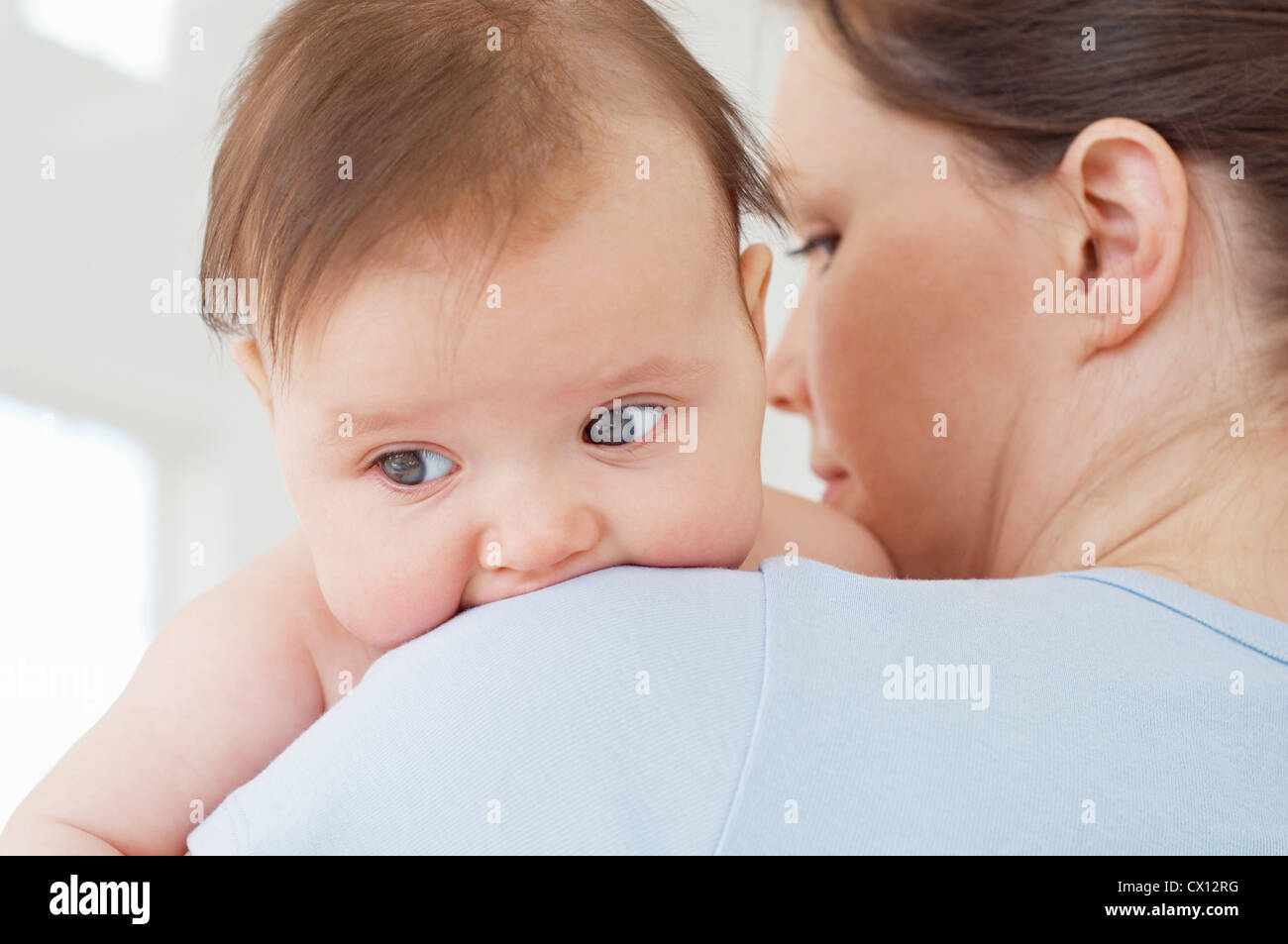 Baby girl on mother's shoulder Stock Photo - Alamy