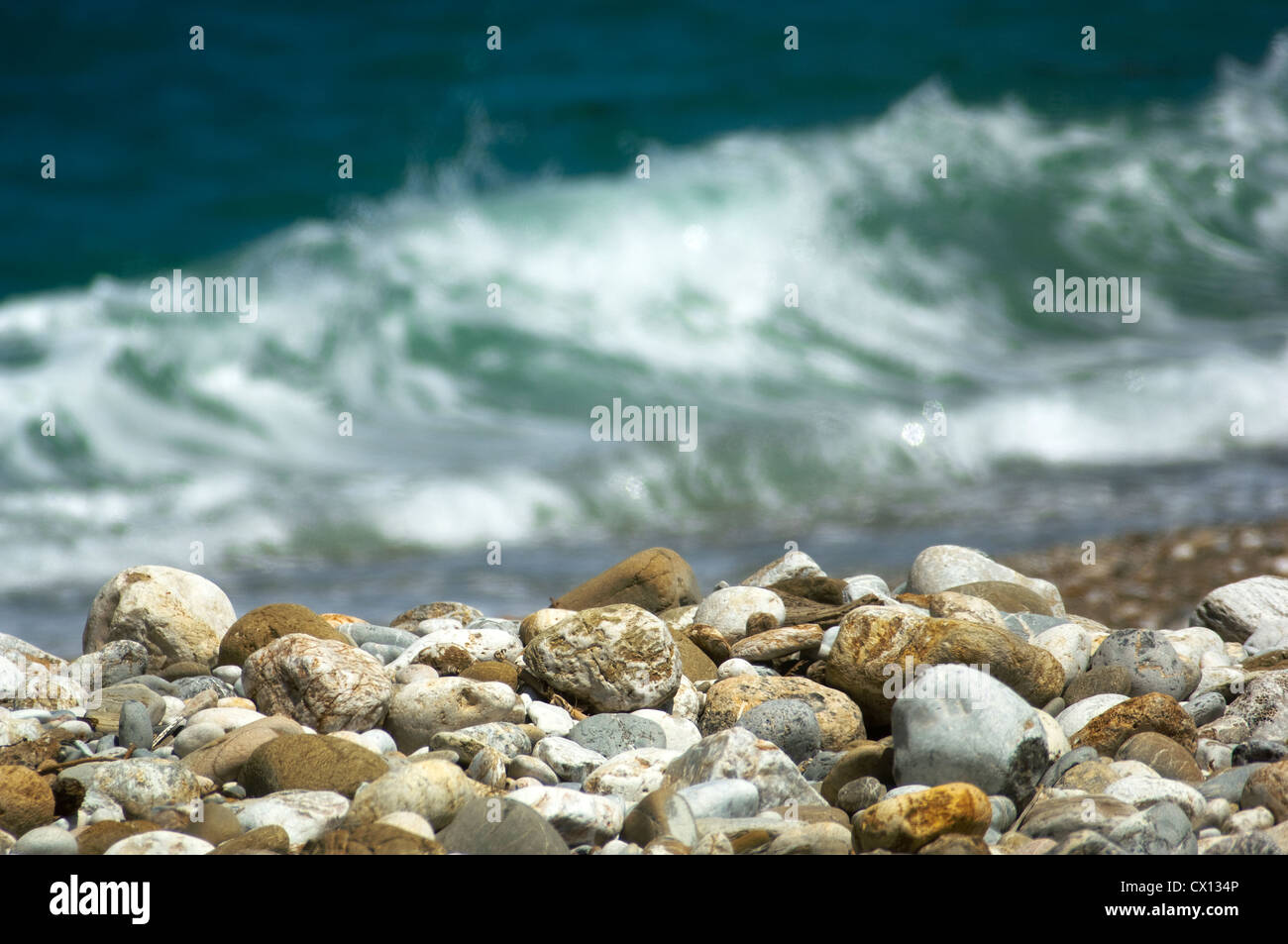 Close-up of a pebble beach with waves in the background Stock Photo - Alamy