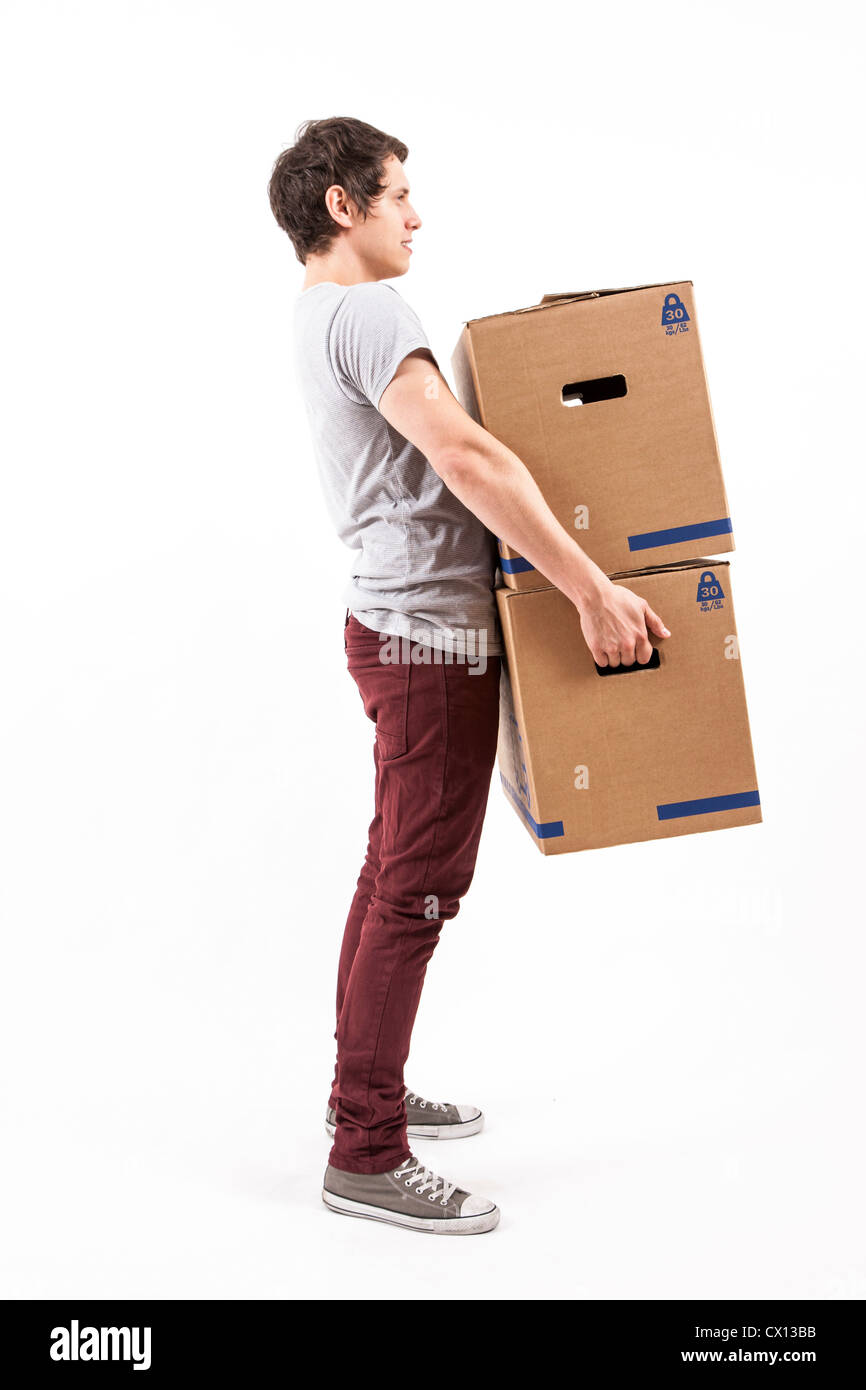 Moving, symbol image. Young man is carrying moving boxes Stock Photo ...