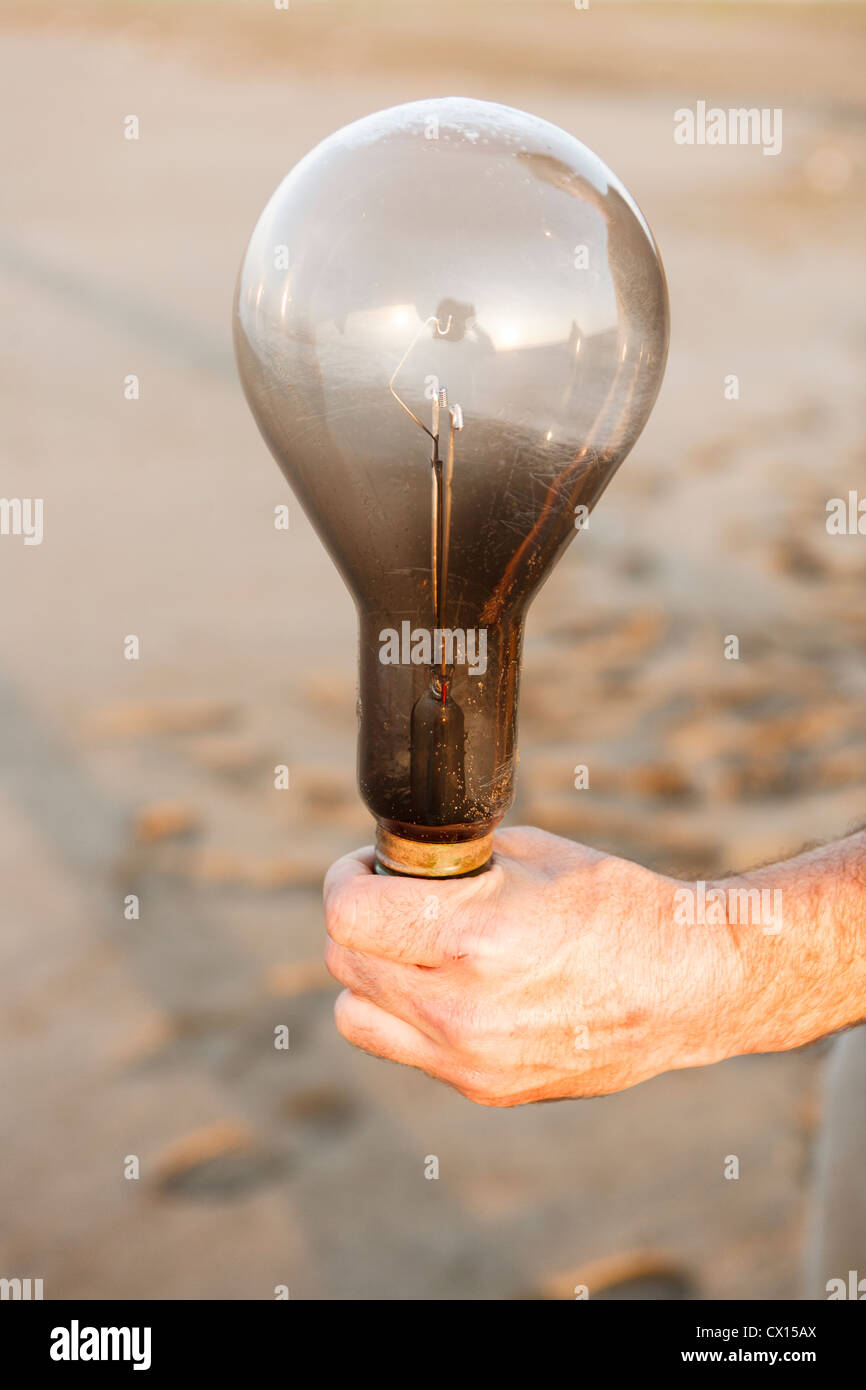 Giant light bulb in the hand Stock Photo - Alamy