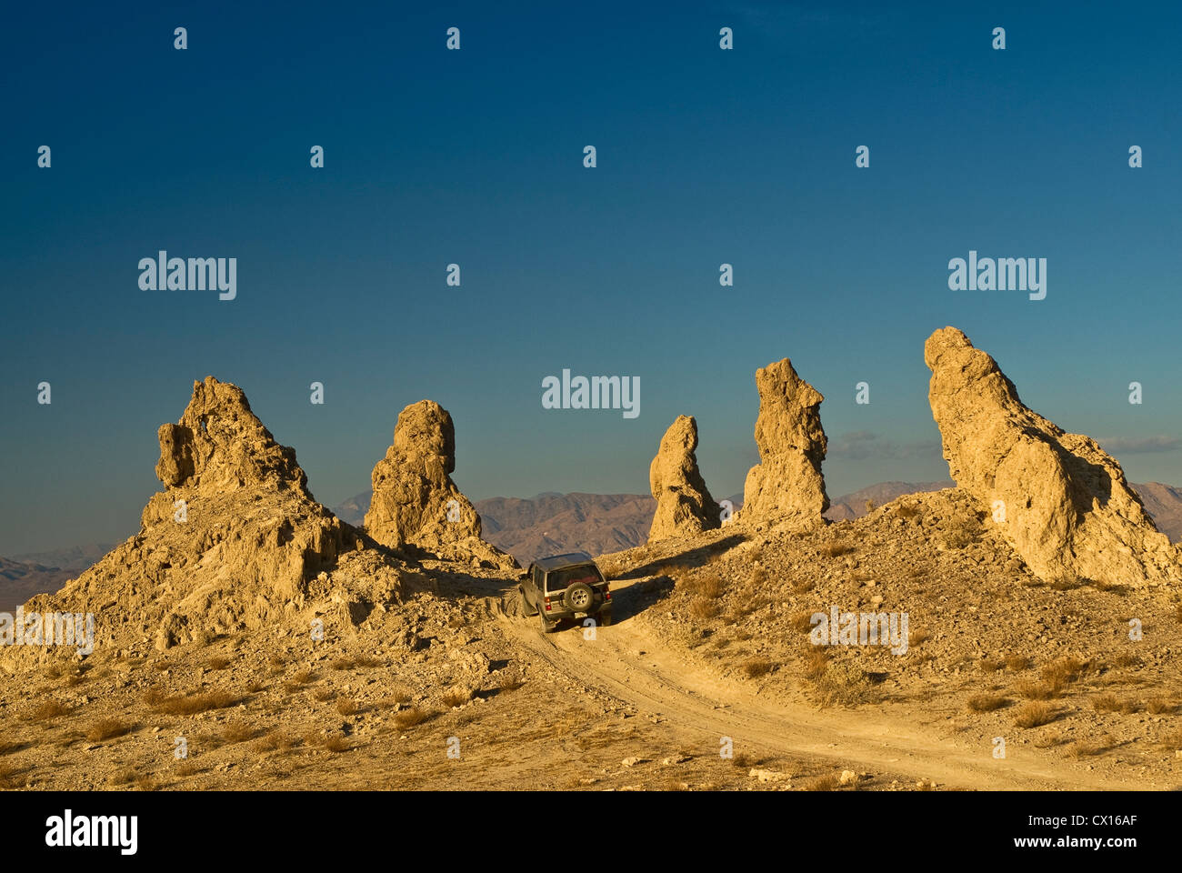 4WD vehicle on dirt road between tufa spires at Trona Pinnacles ...