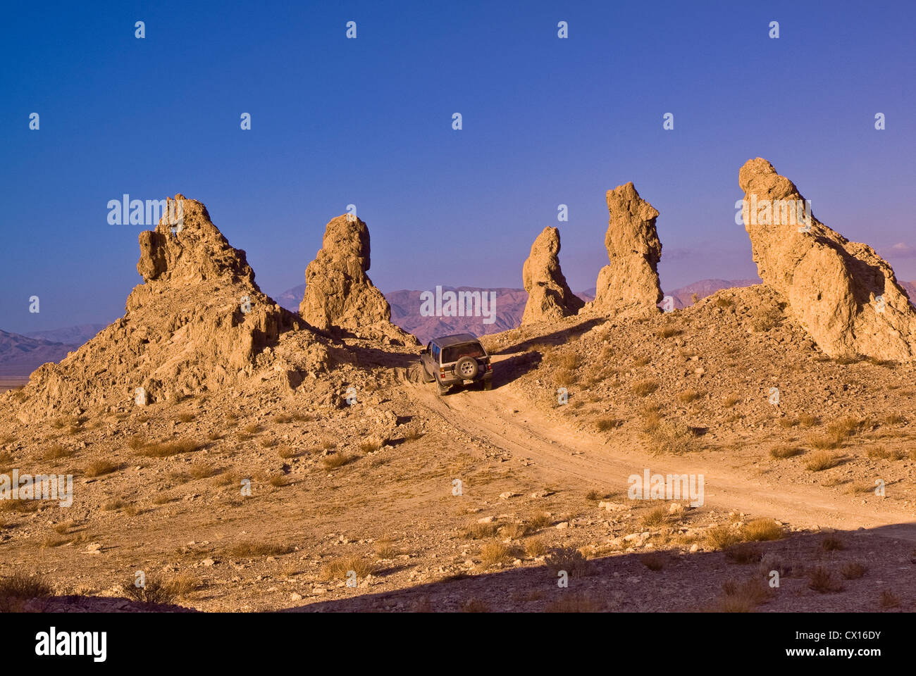 4WD vehicle on dirt road between tufa spires at Trona Pinnacles ...
