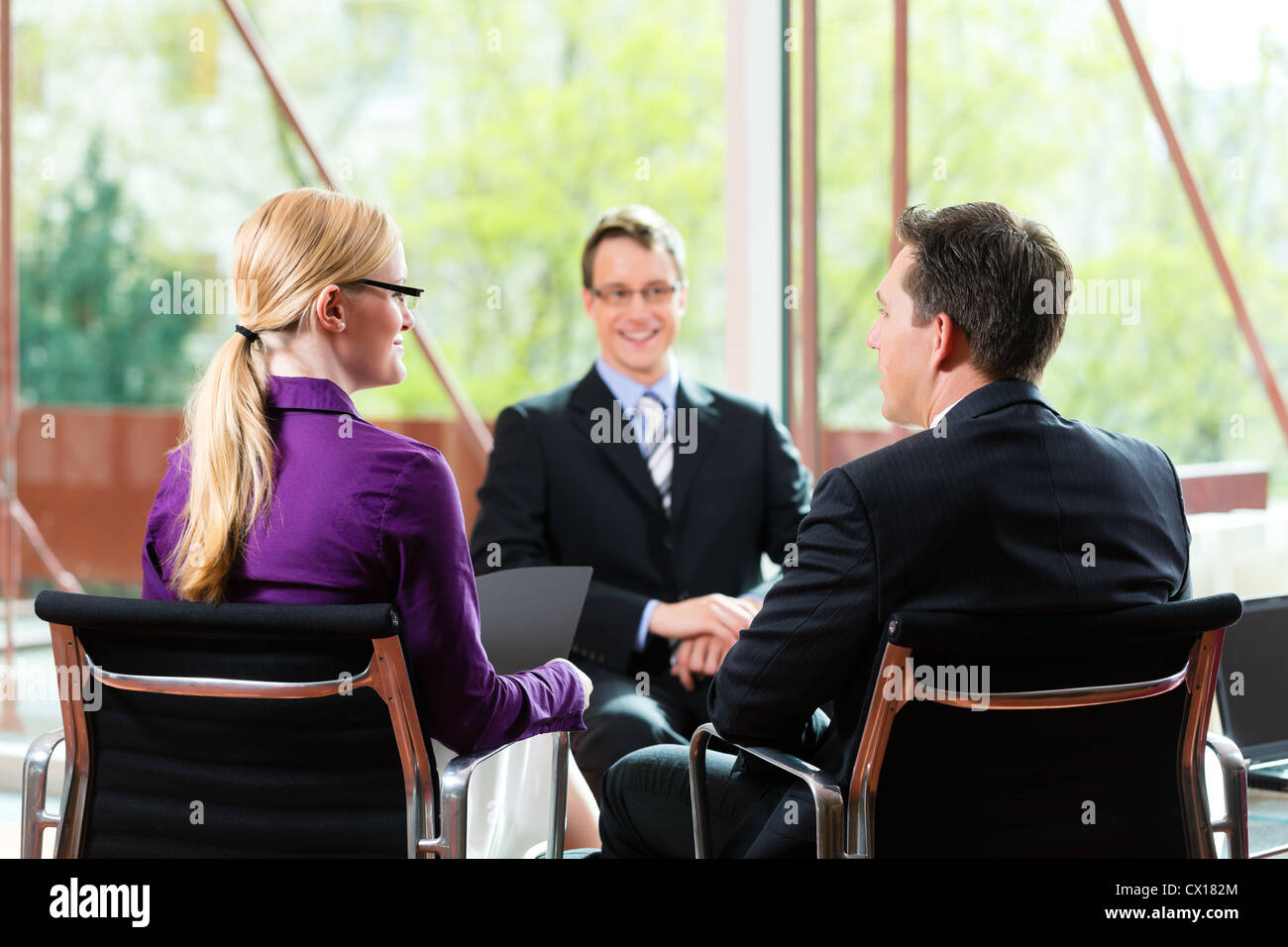 Business - young man as applicant sitting in job interview with future ...