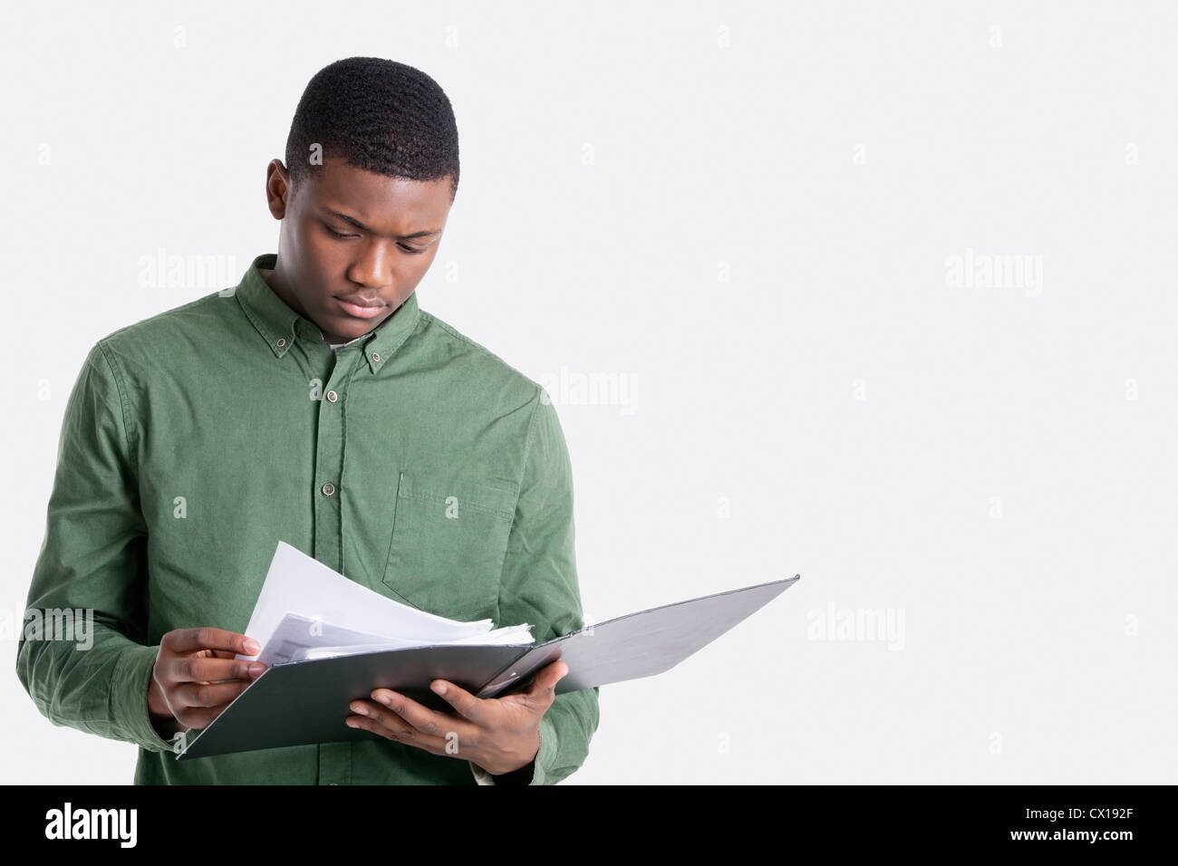 Young African American man reading documents over gray background Stock ...