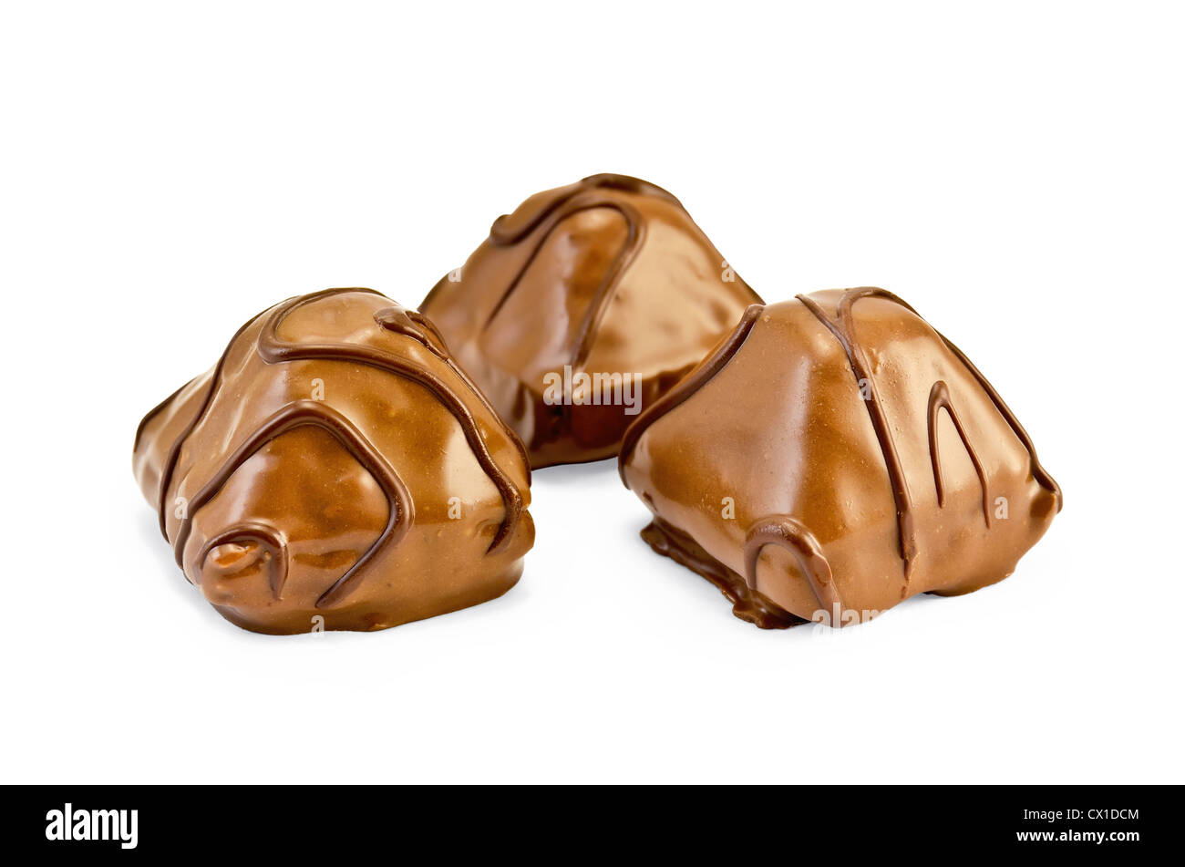 Three whole chocolate candies with a pattern isolated on a white ...