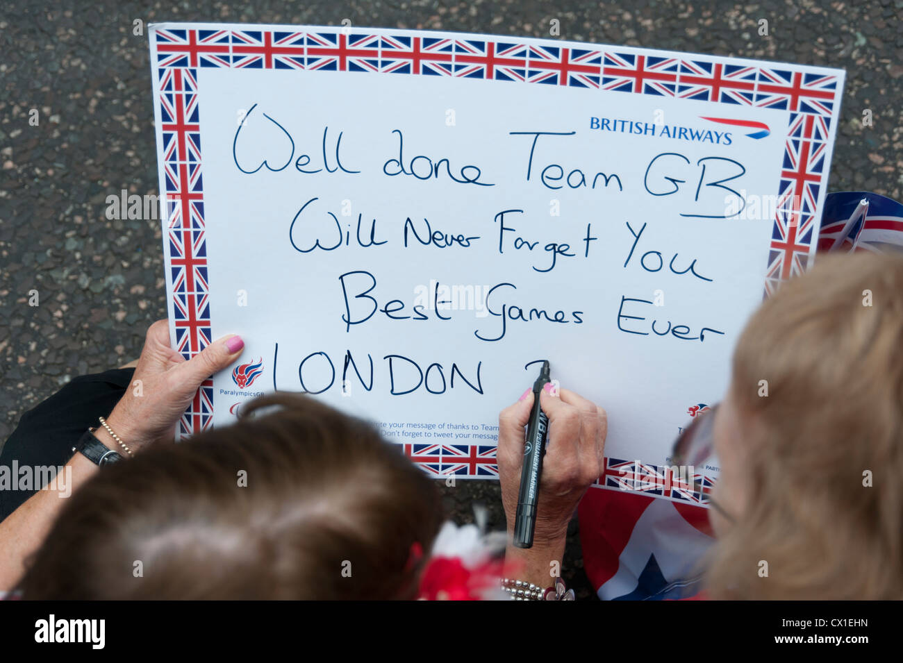Spectators write a message on a card at the London Olympics 2012 Team ...