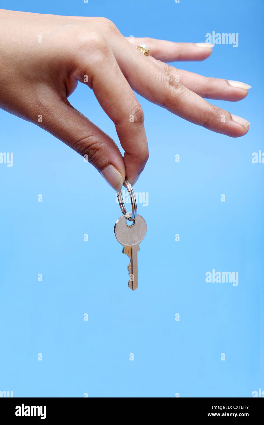 Key in hand isolated on blue background Stock Photo - Alamy