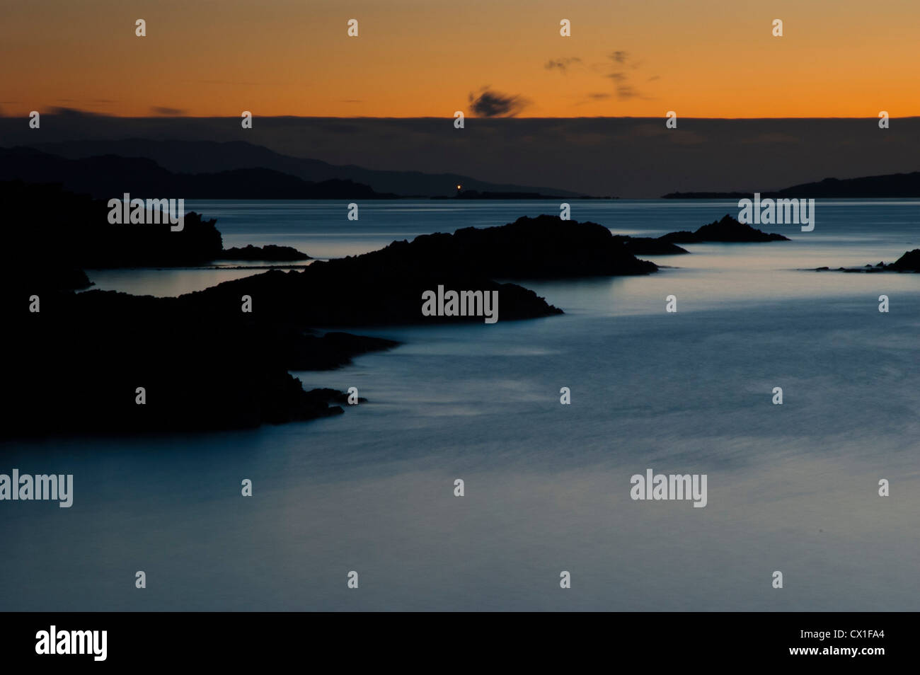 Seil Island looking out to the Garvellachs with Fladda lighthouse in ...