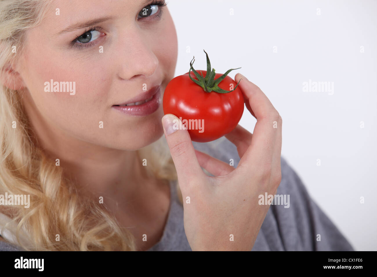 Woman eating a tomato Stock Photo - Alamy